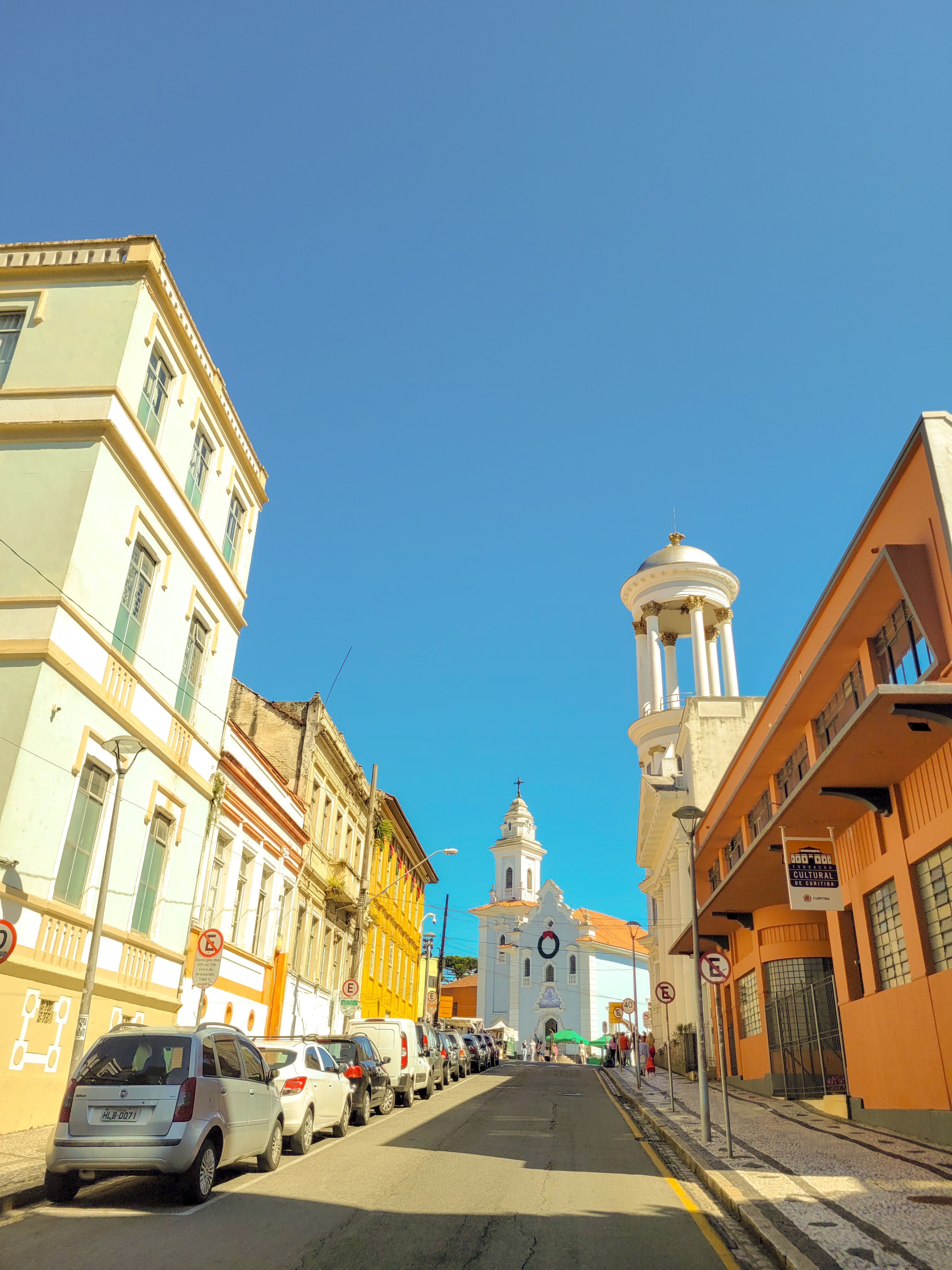 A street with a church tower in the background · Free Stock Photo
