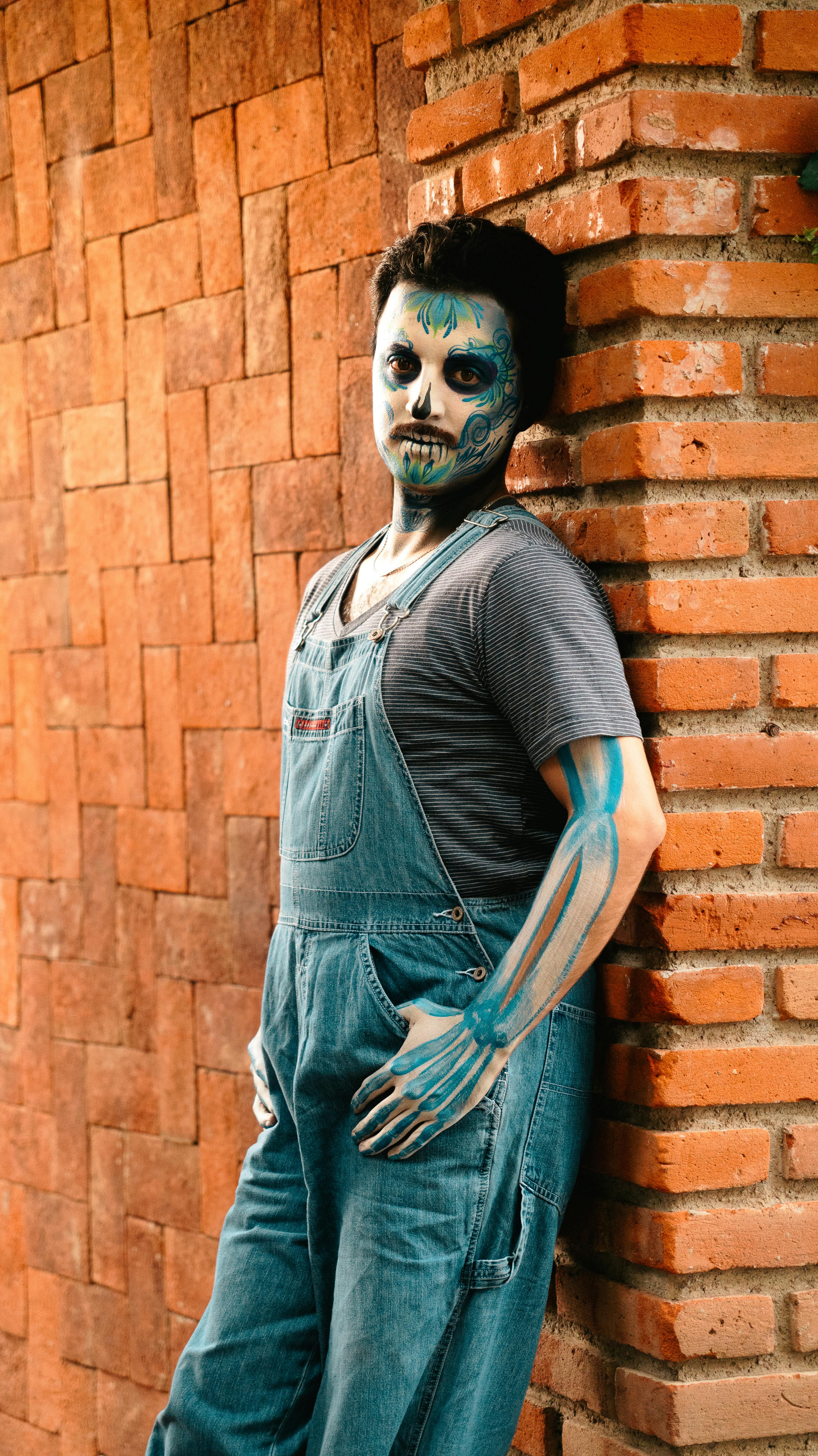 Man with Sugar Skull Makeup Leaning on Brick Wall · Free Stock Photo