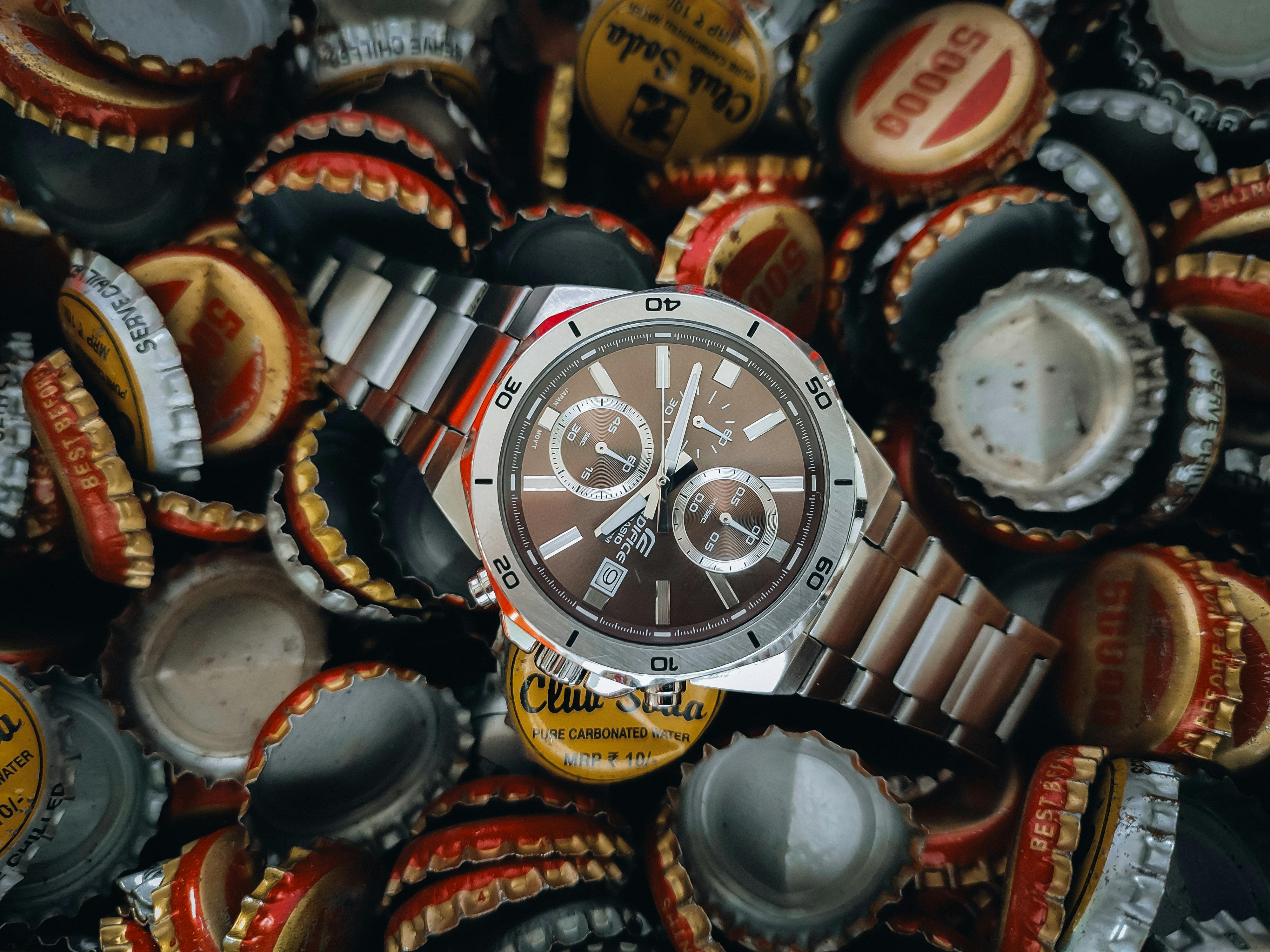 Close-up of a Wristwatch Lying on Bottle Caps · Free Stock Photo