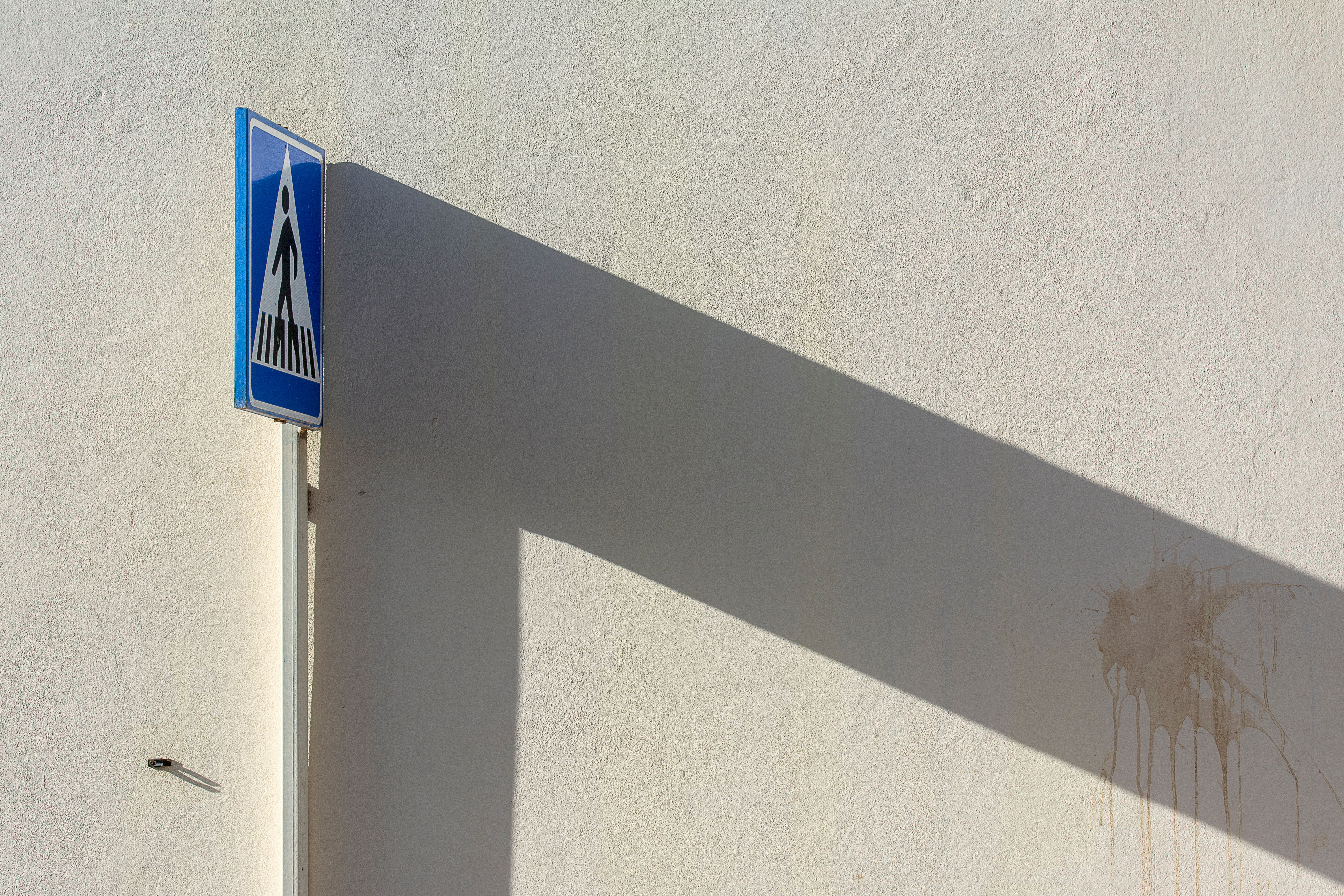 A blue and white sign on a white wall · Free Stock Photo