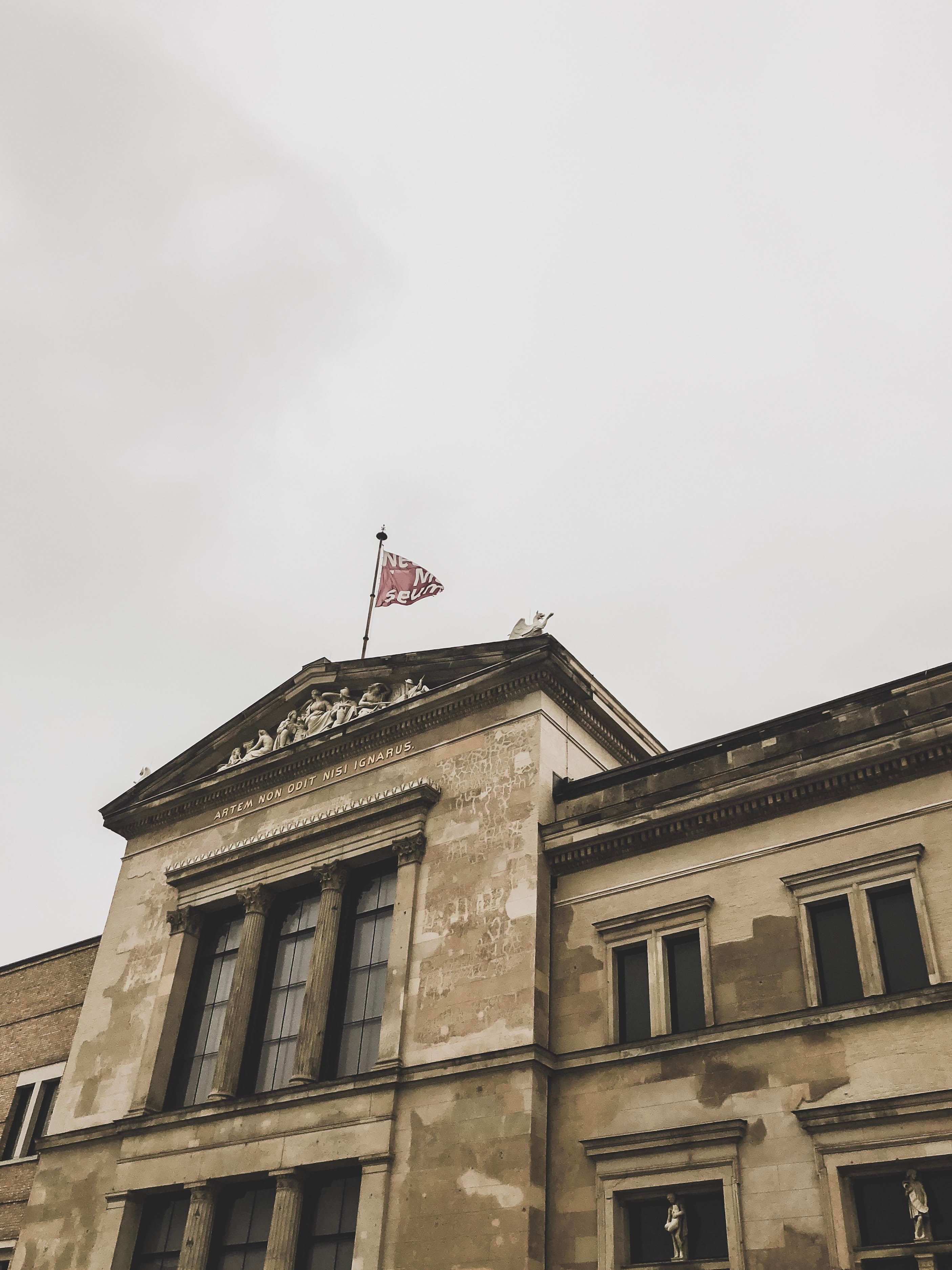 A building with a flag flying in the sky · Free Stock Photo