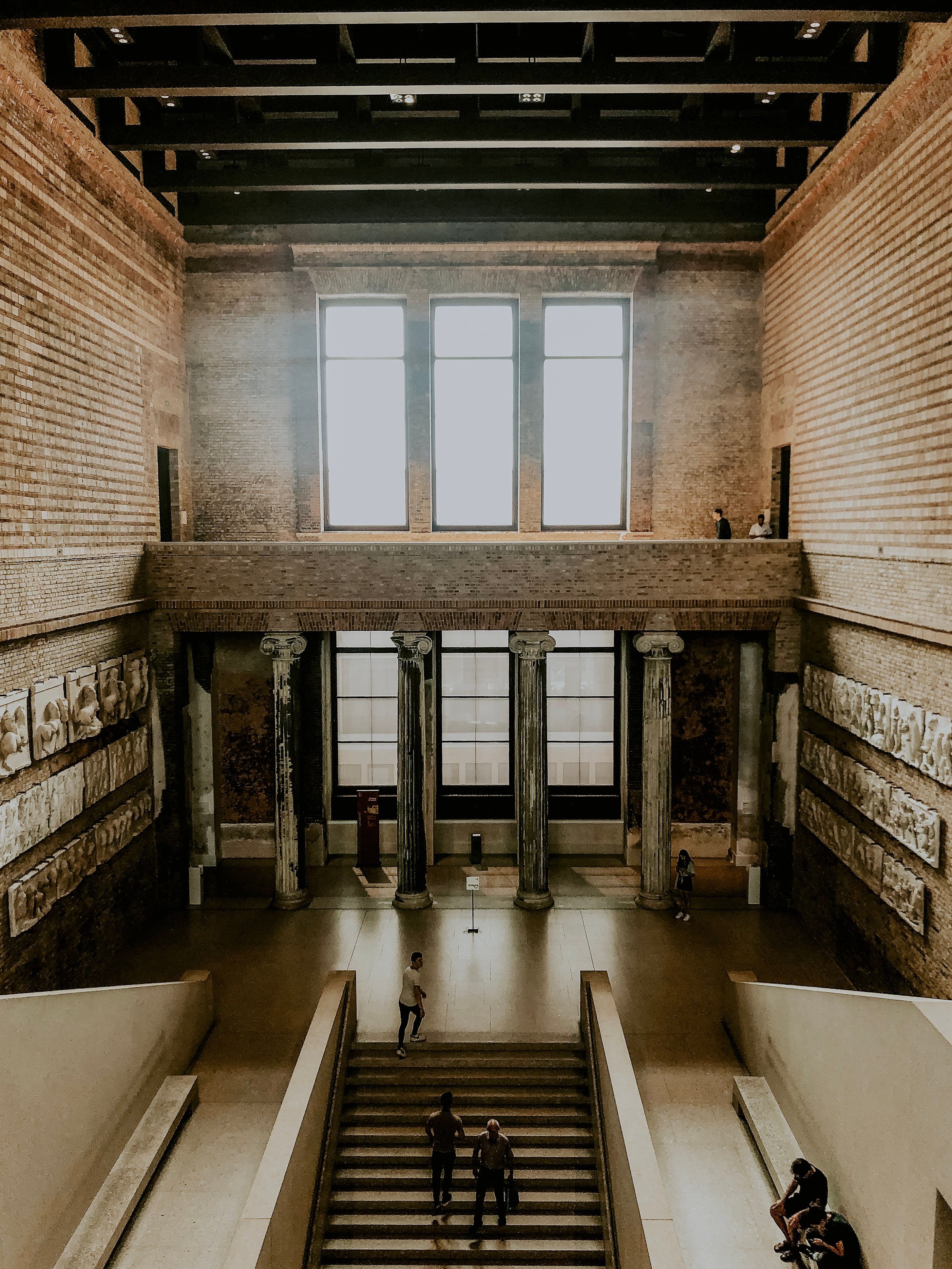 The inside of a building with stairs and columns · Free Stock Photo