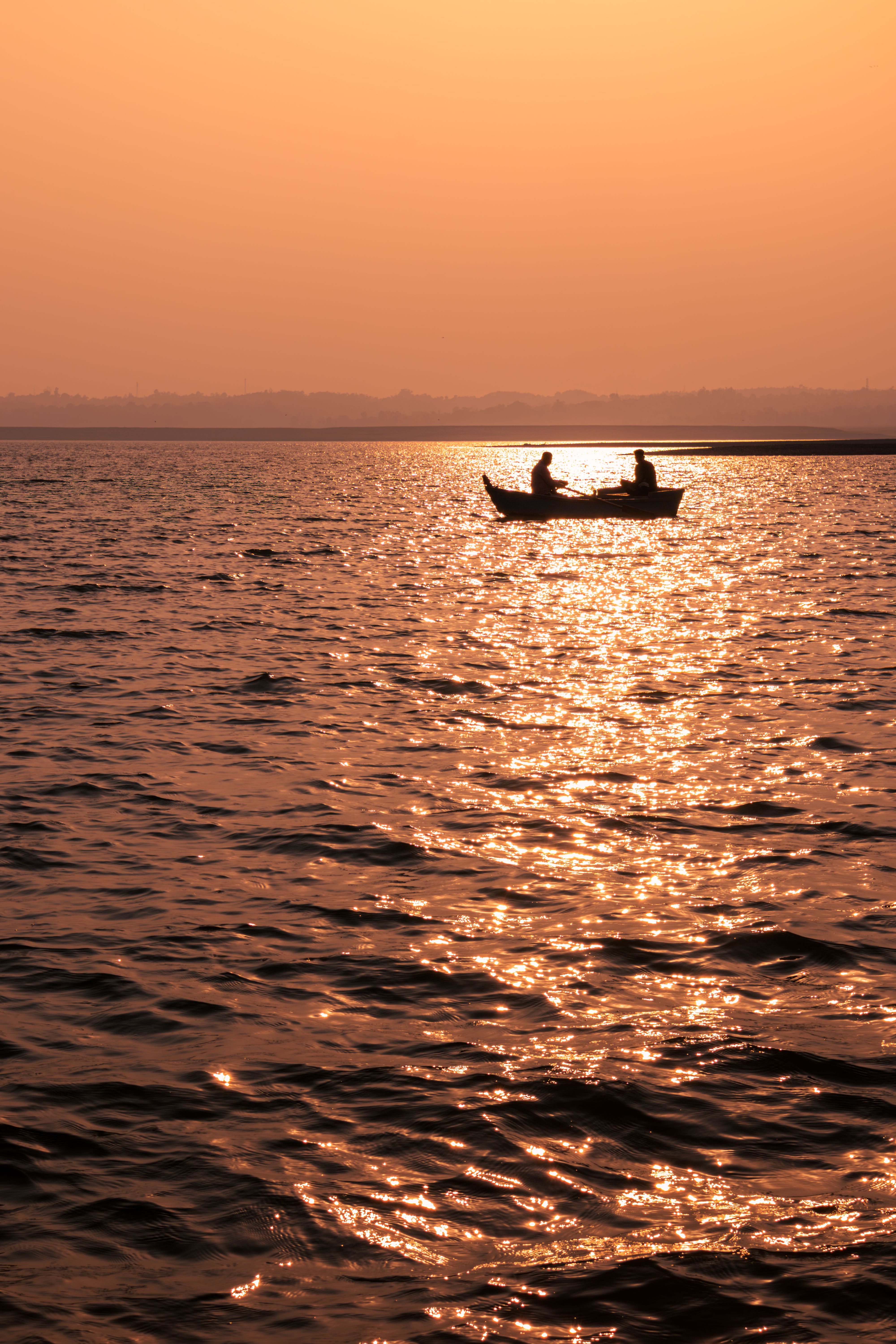 People on Boat on Sea Coast at Sunset · Free Stock Photo