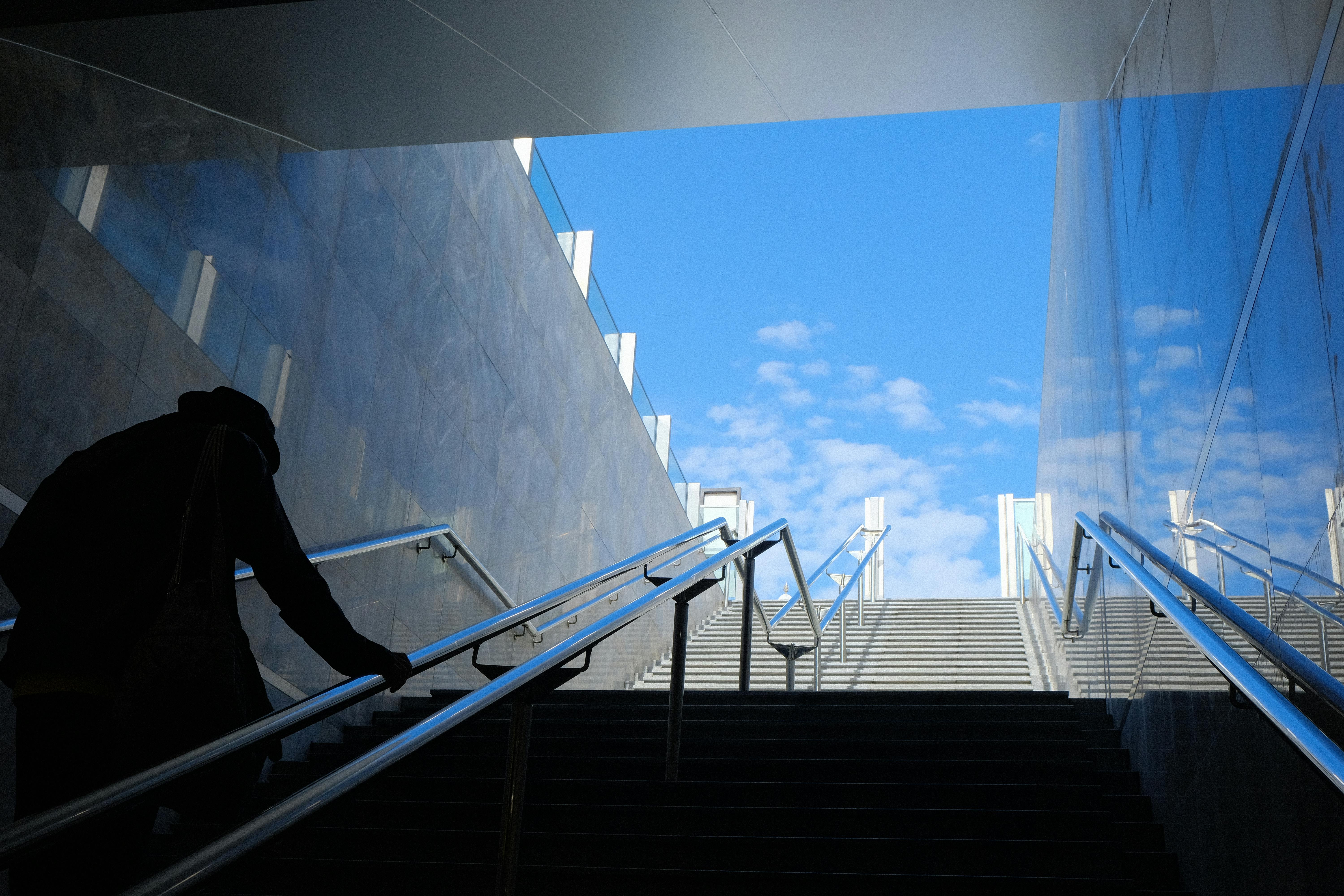 Silhouette of Person Exiting Subway Station to Blue Sky · Free Stock Photo