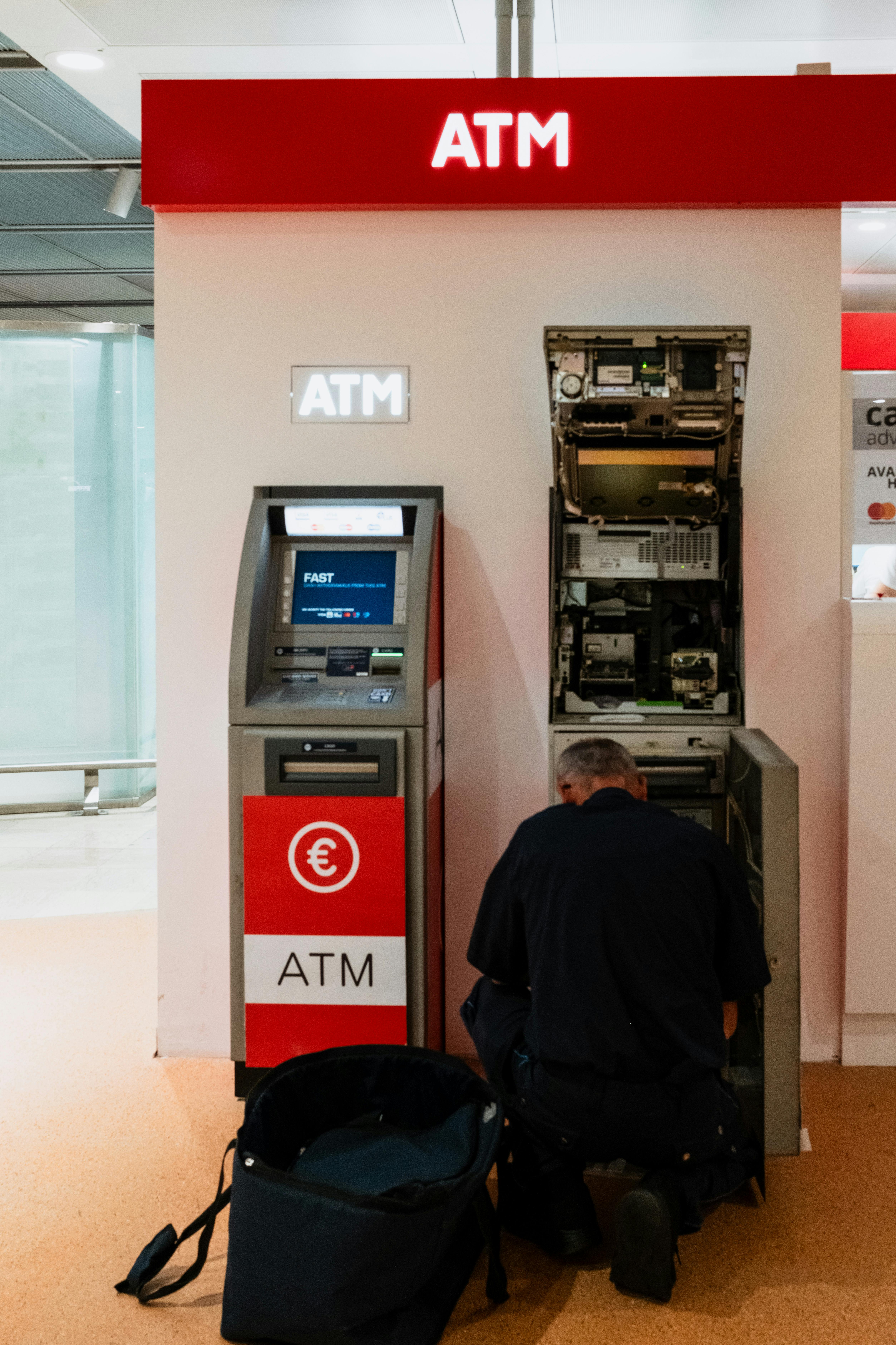 Man Fixing an ATM Machine · Free Stock Photo