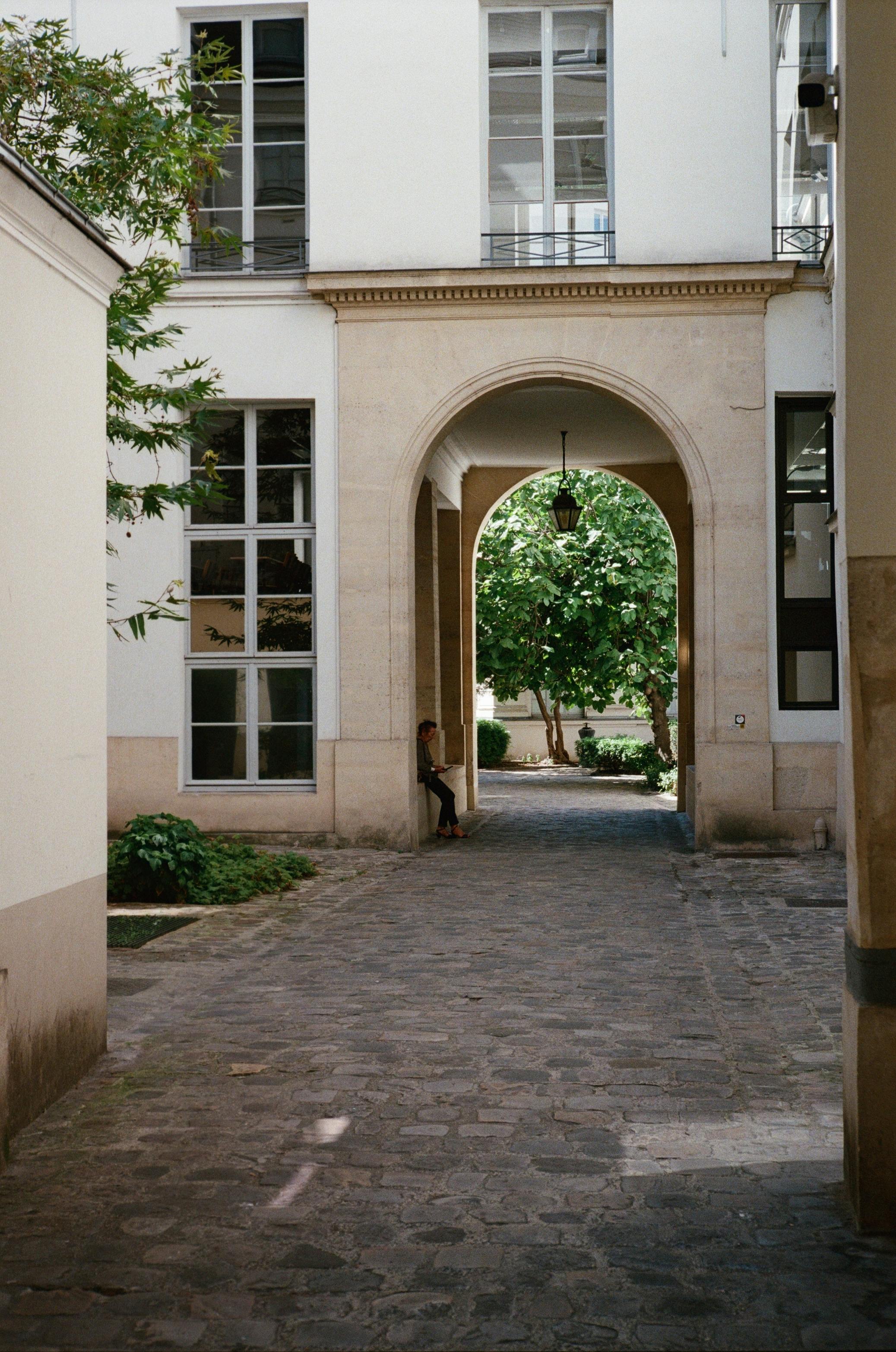 Serene Urban Courtyard with Archway and Foliage · Free Stock Photo