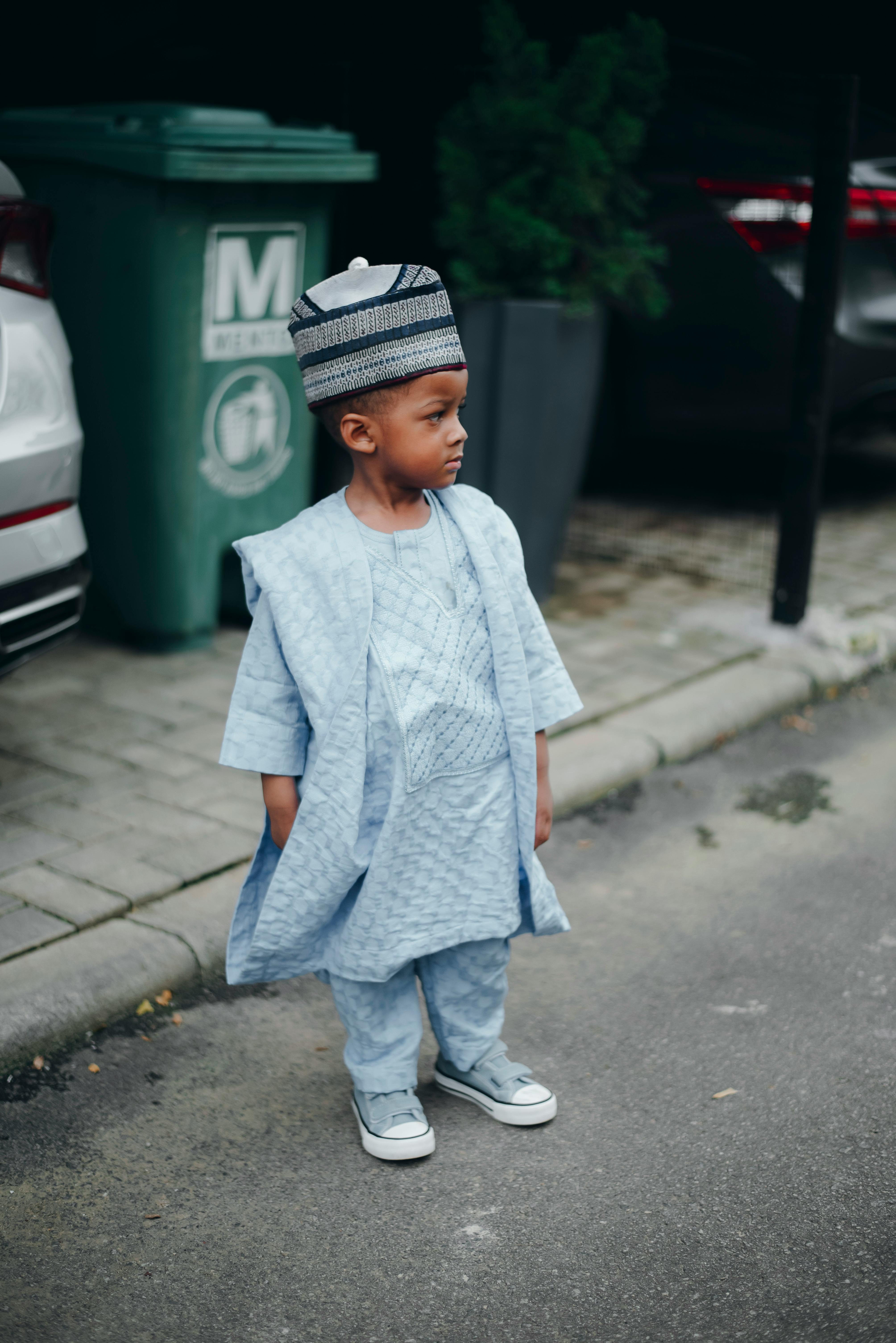Little Boy in Traditional Blue Agbada and Hausa Cap · Free Stock Photo