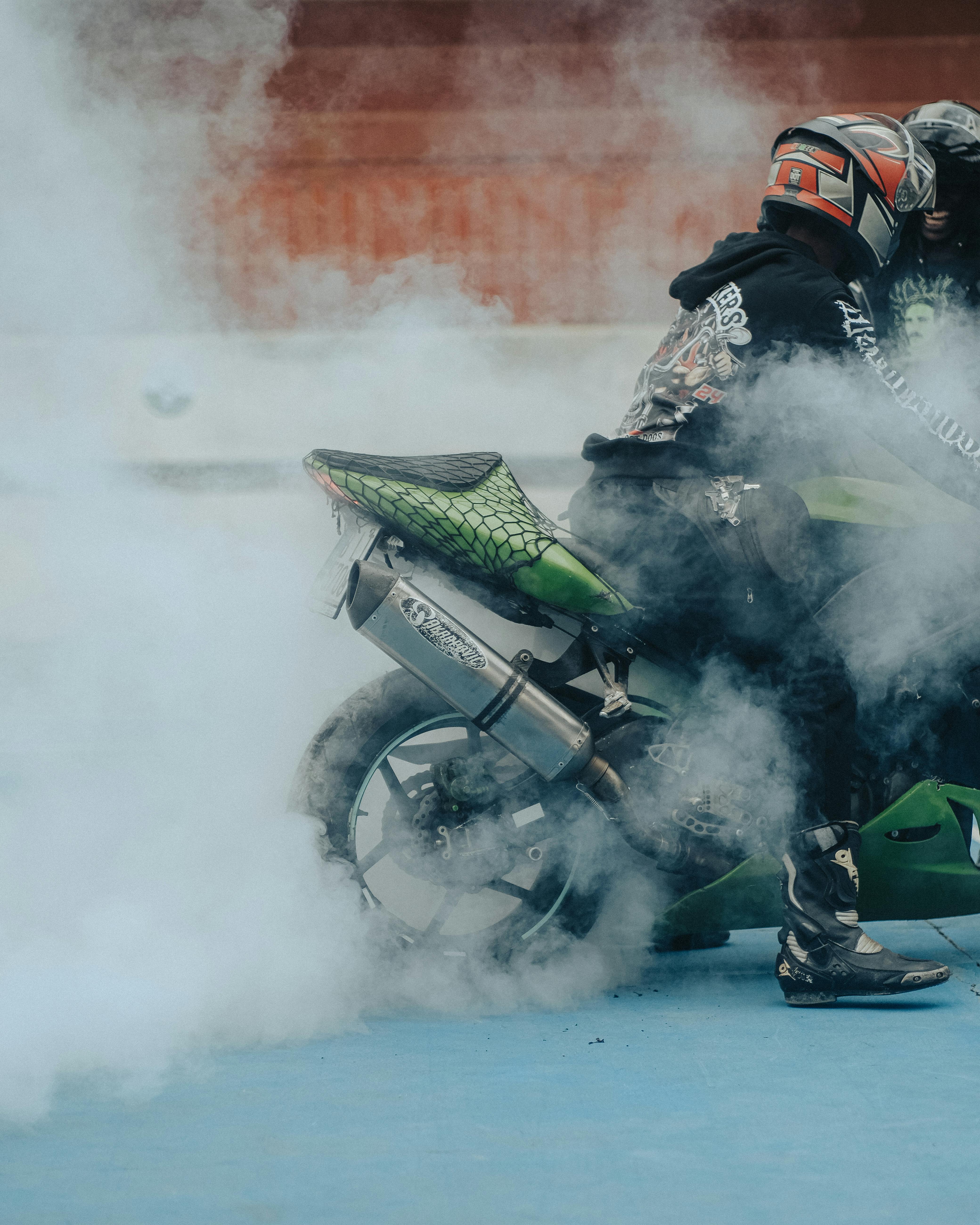 A man on a motorcycle is surrounded by smoke · Free Stock Photo