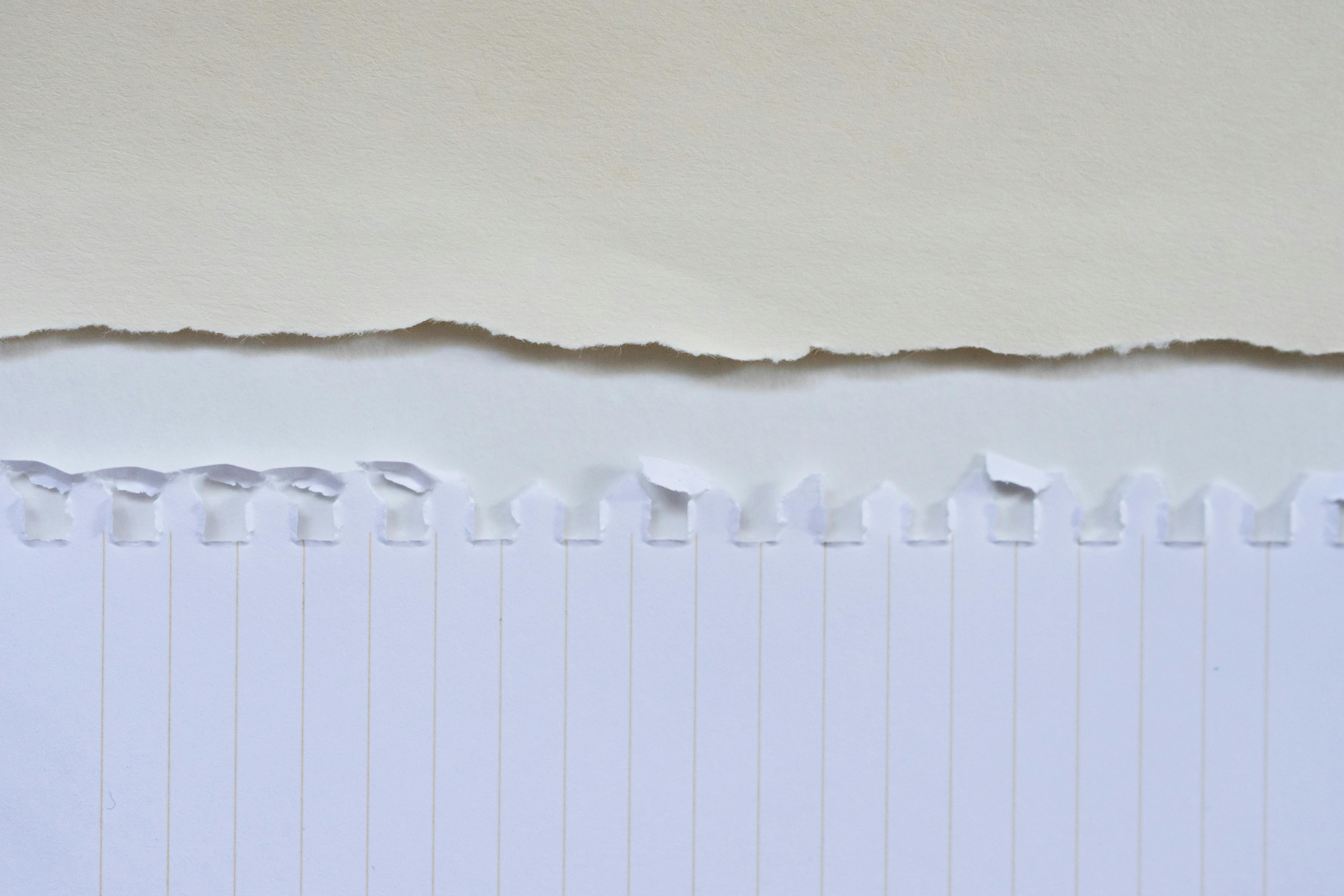 A torn piece of paper with a piece of paper on top · Free Stock Photo