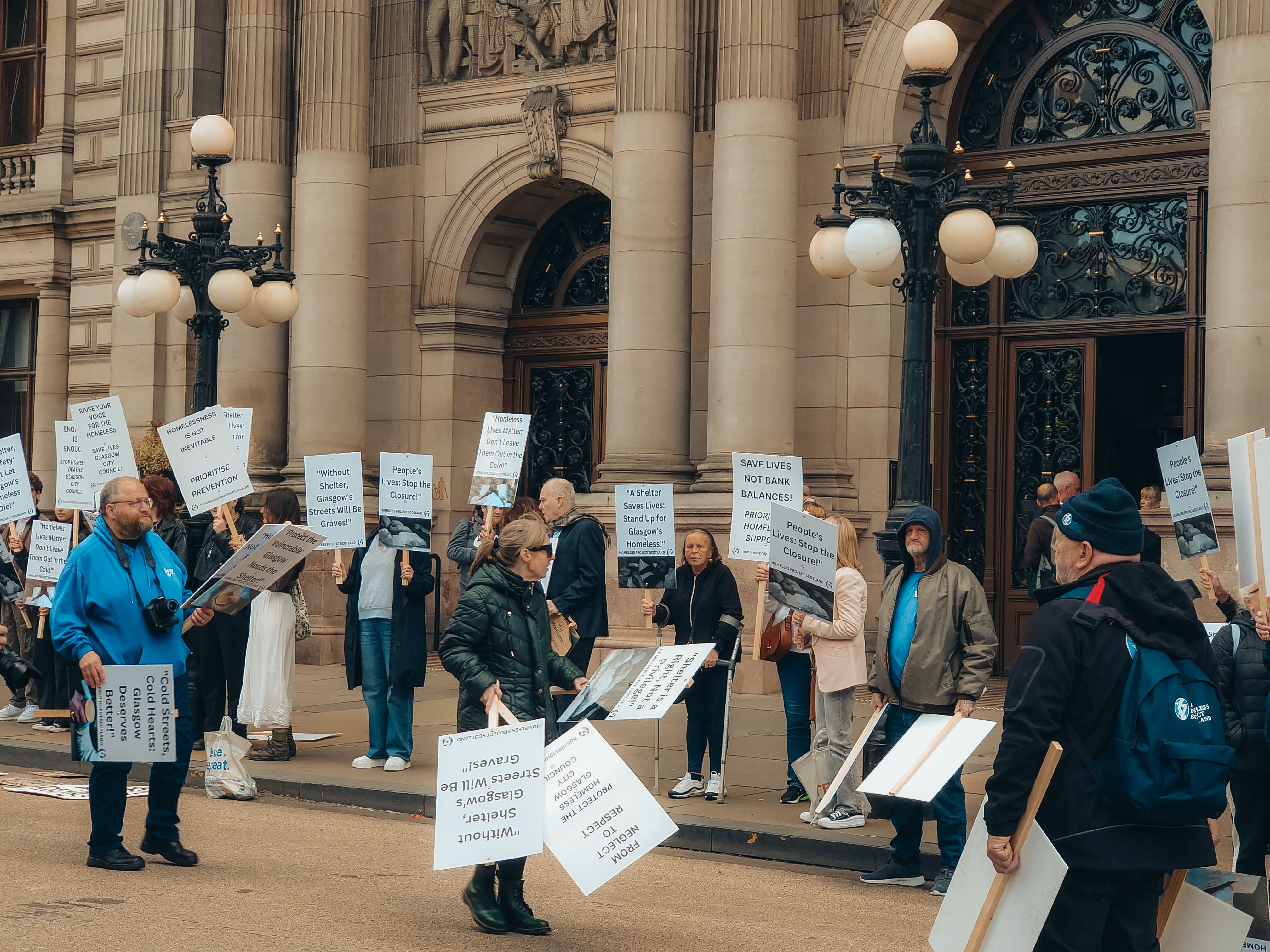 A group of people holding signs in front of a building · Free Stock Photo