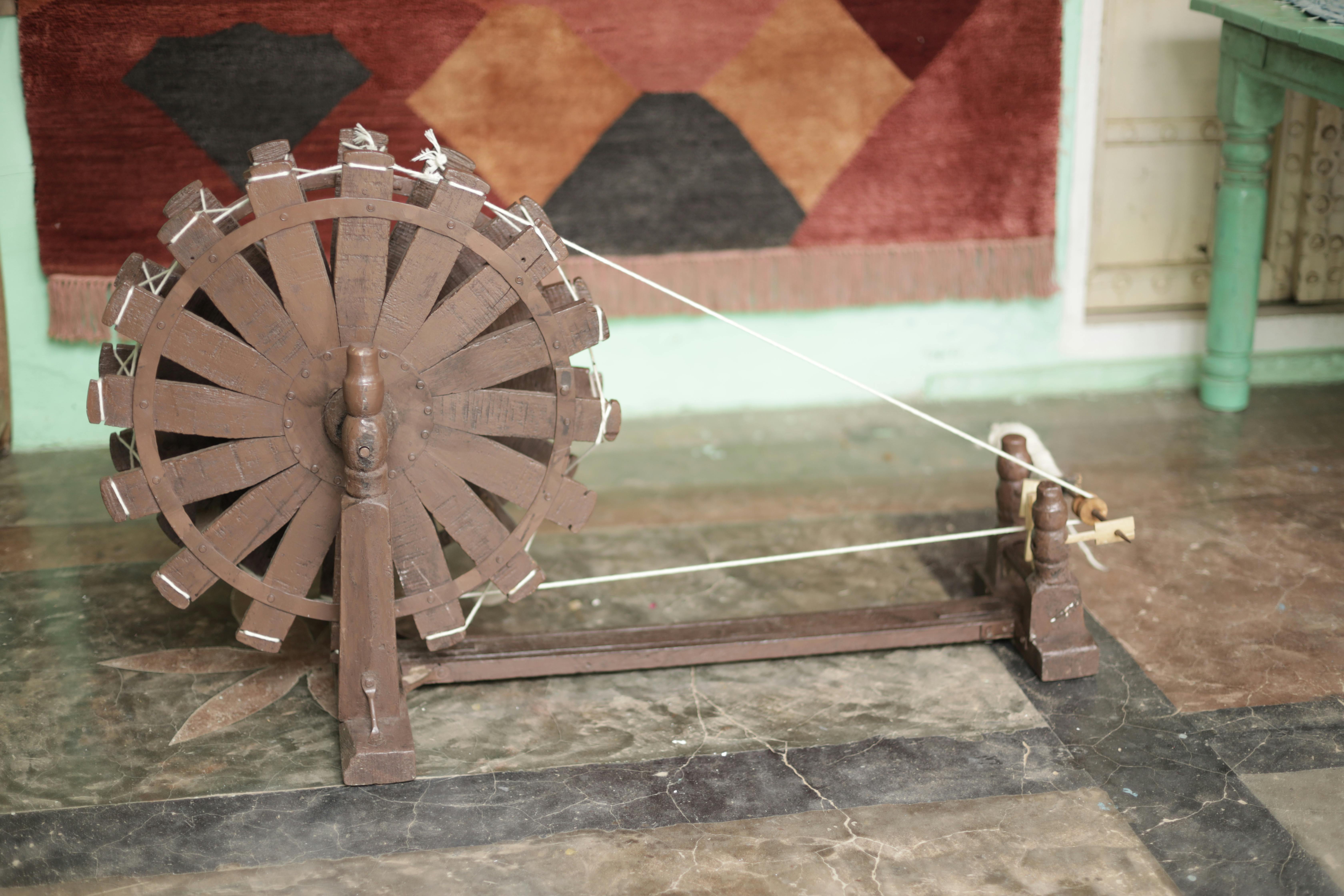 Traditional Spinning Wheel on Rustic Indoor Floor · Free Stock Photo