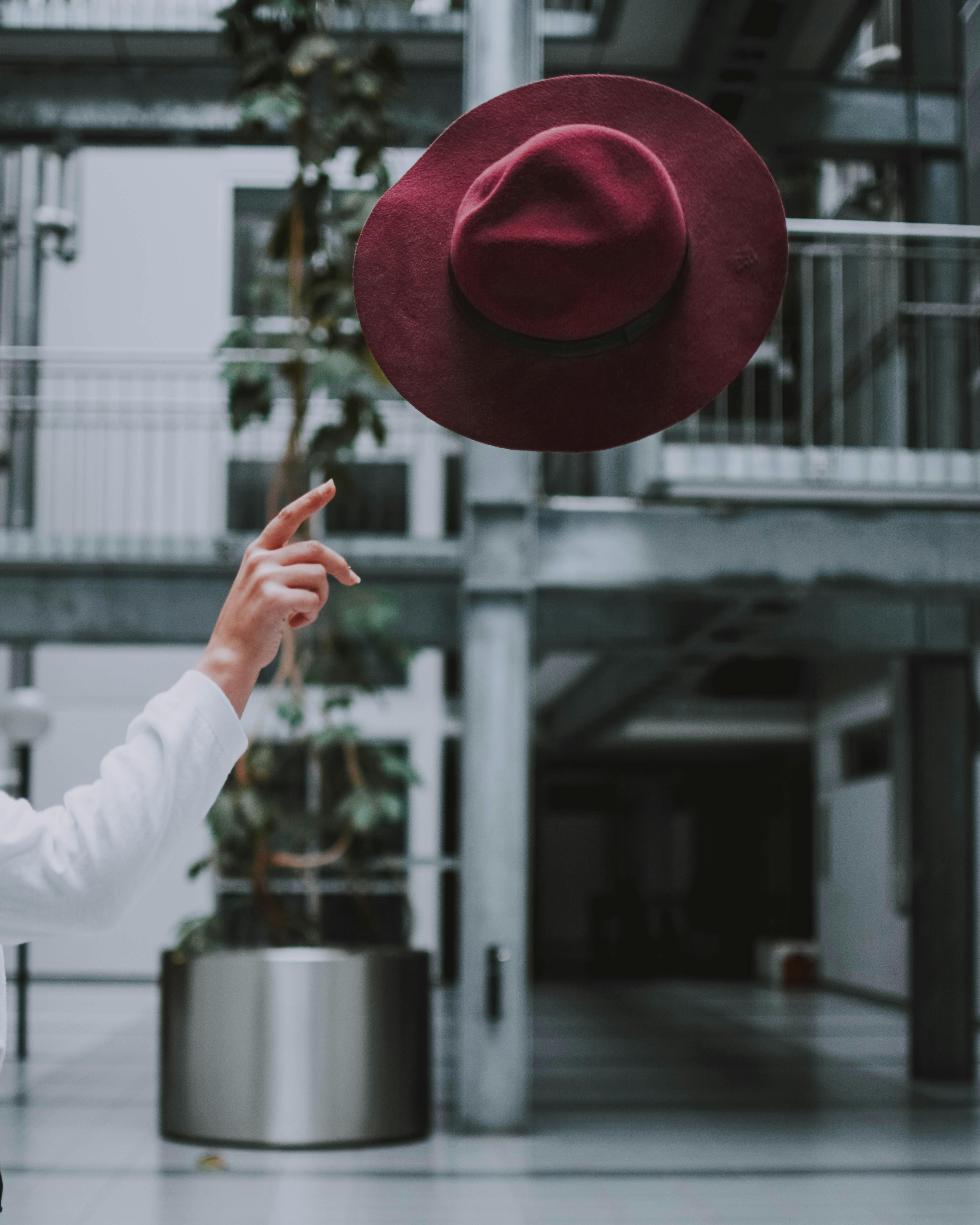 Person's Hand About to Throw Red Fedora Hat · Free Stock Photo
