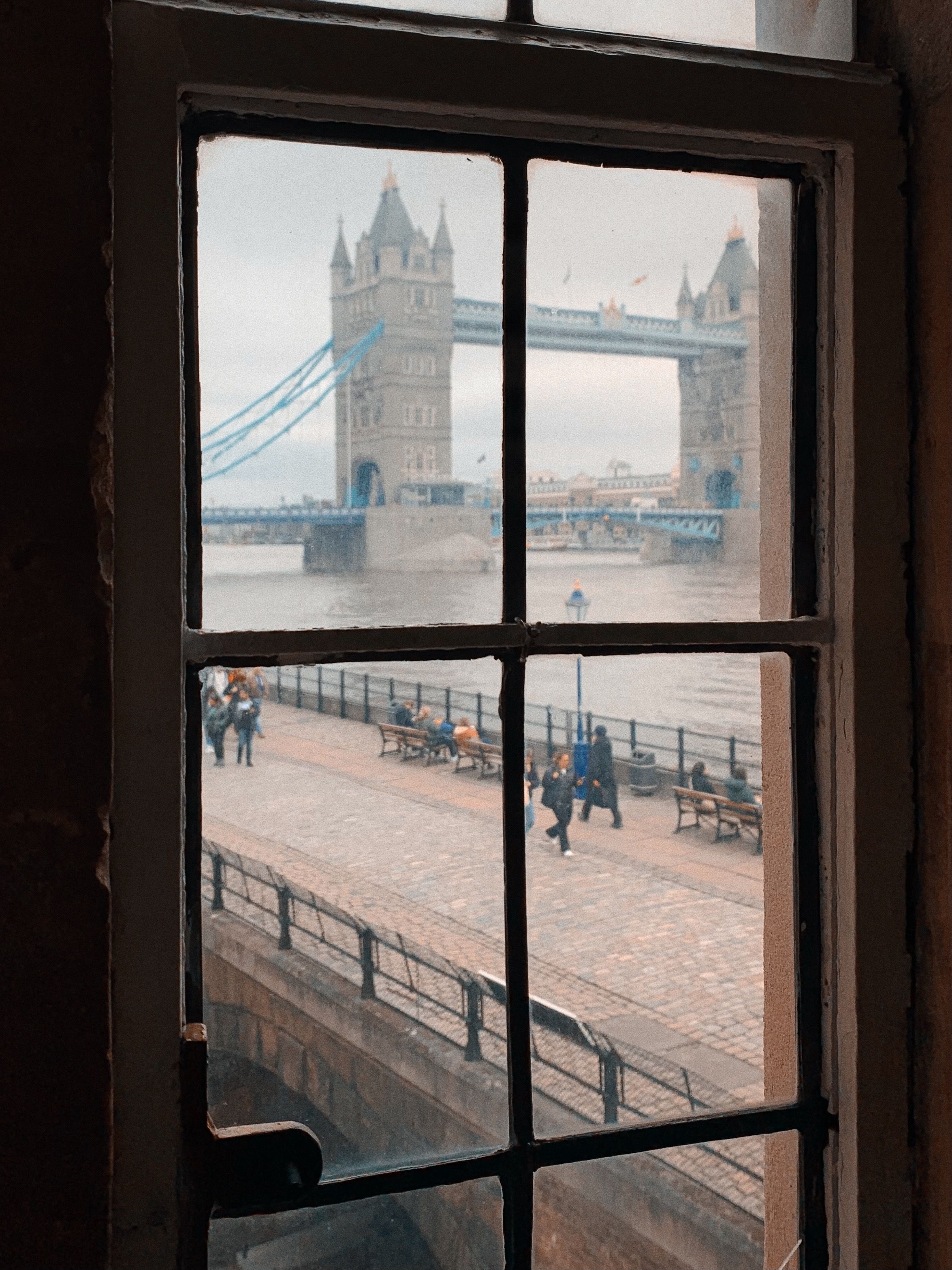 View of Tower Bridge of London from an old window on a cloudy day ...