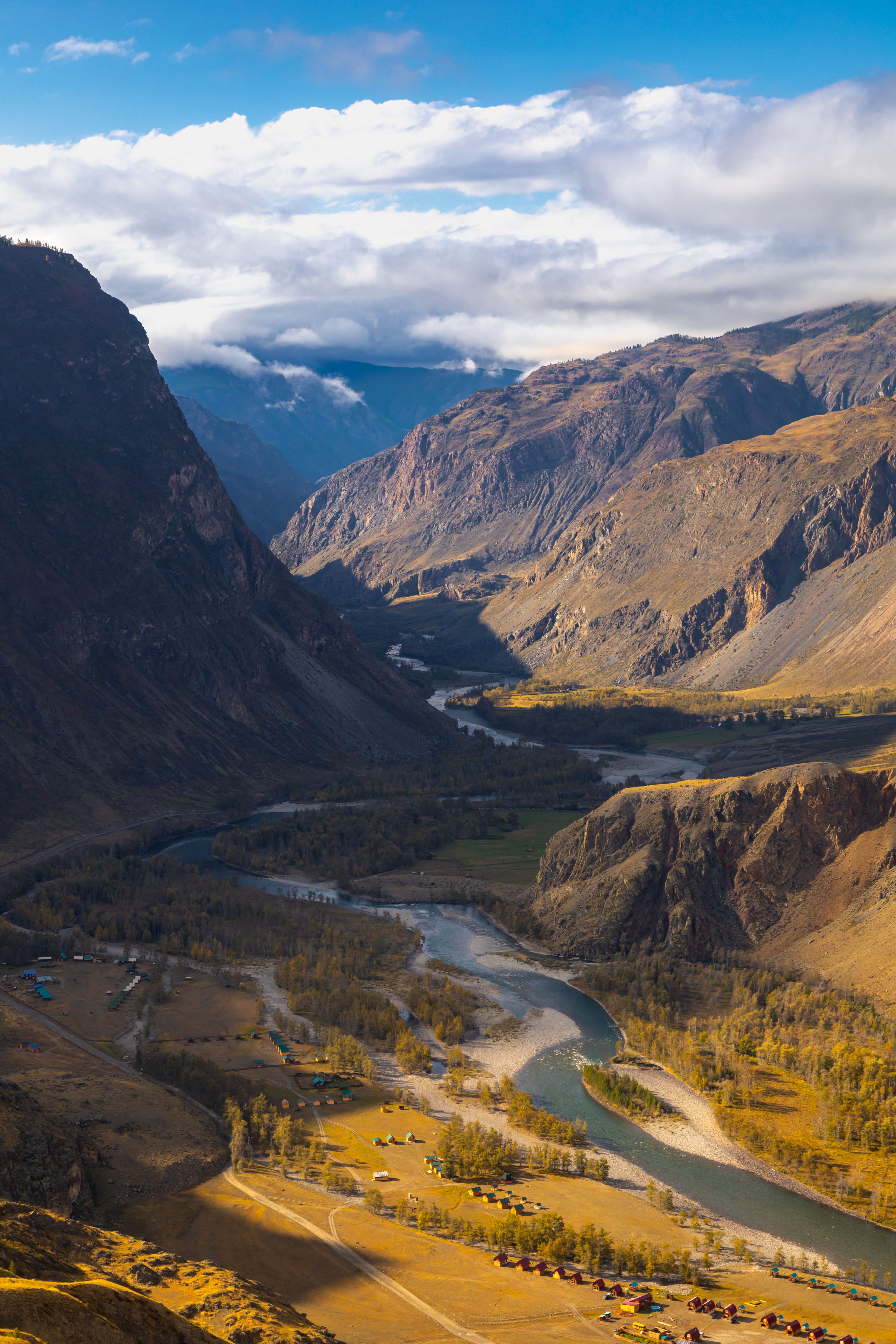 A scenic view of a valley with mountains and a river · Free Stock Photo