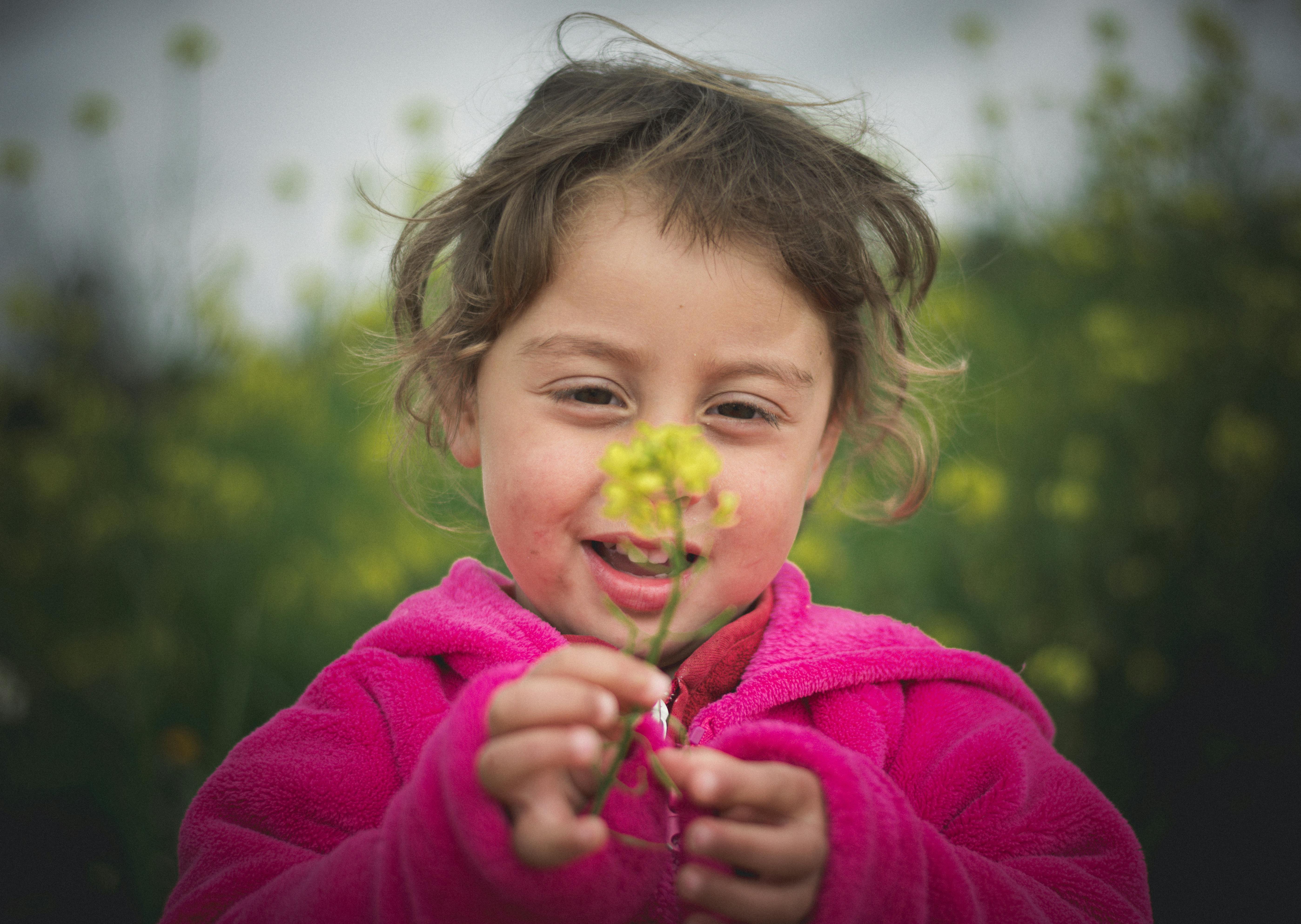 Kid girl playing with flowers · Free Stock Photo