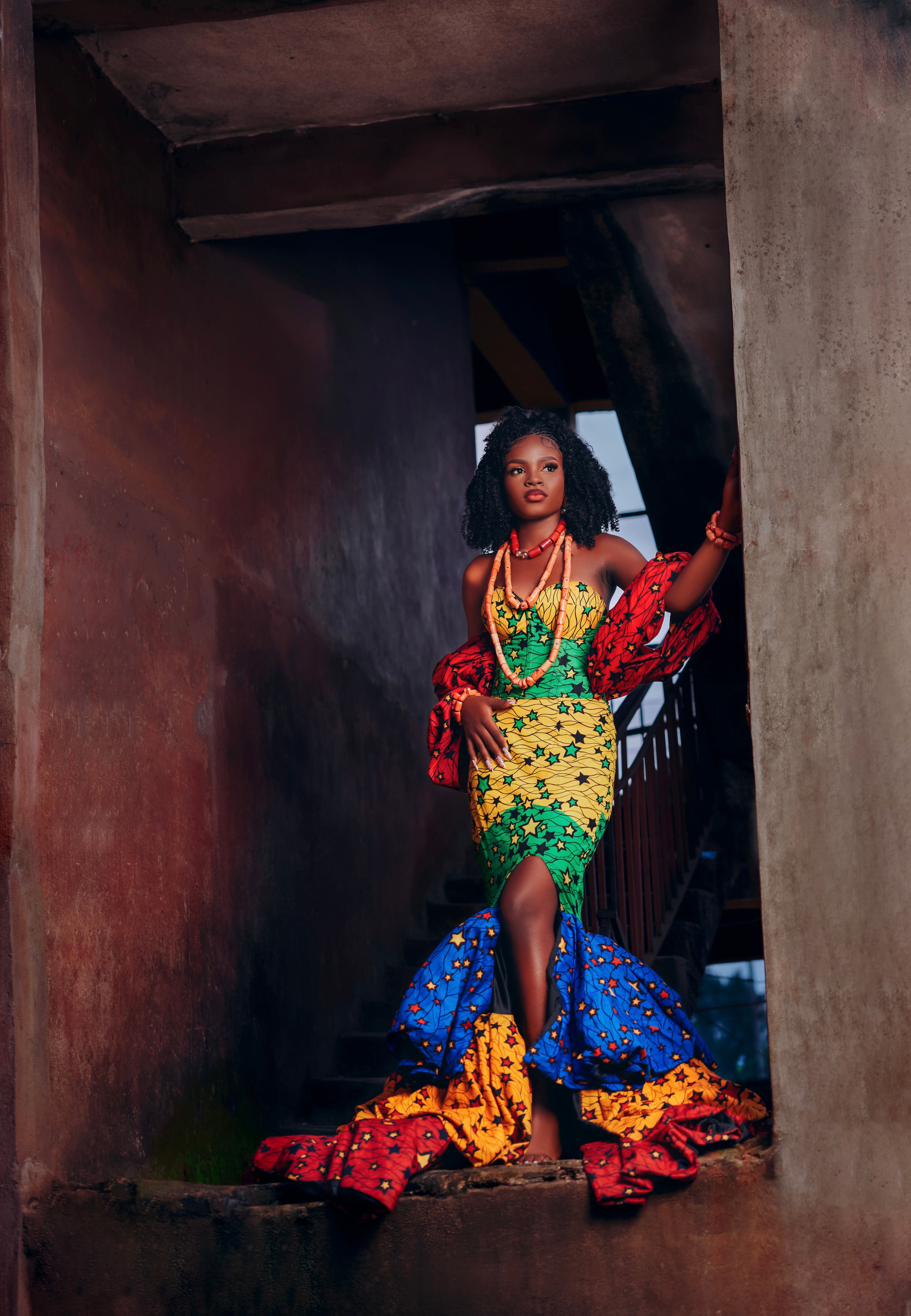 A woman in colorful clothing posing on a staircase · Free Stock Photo