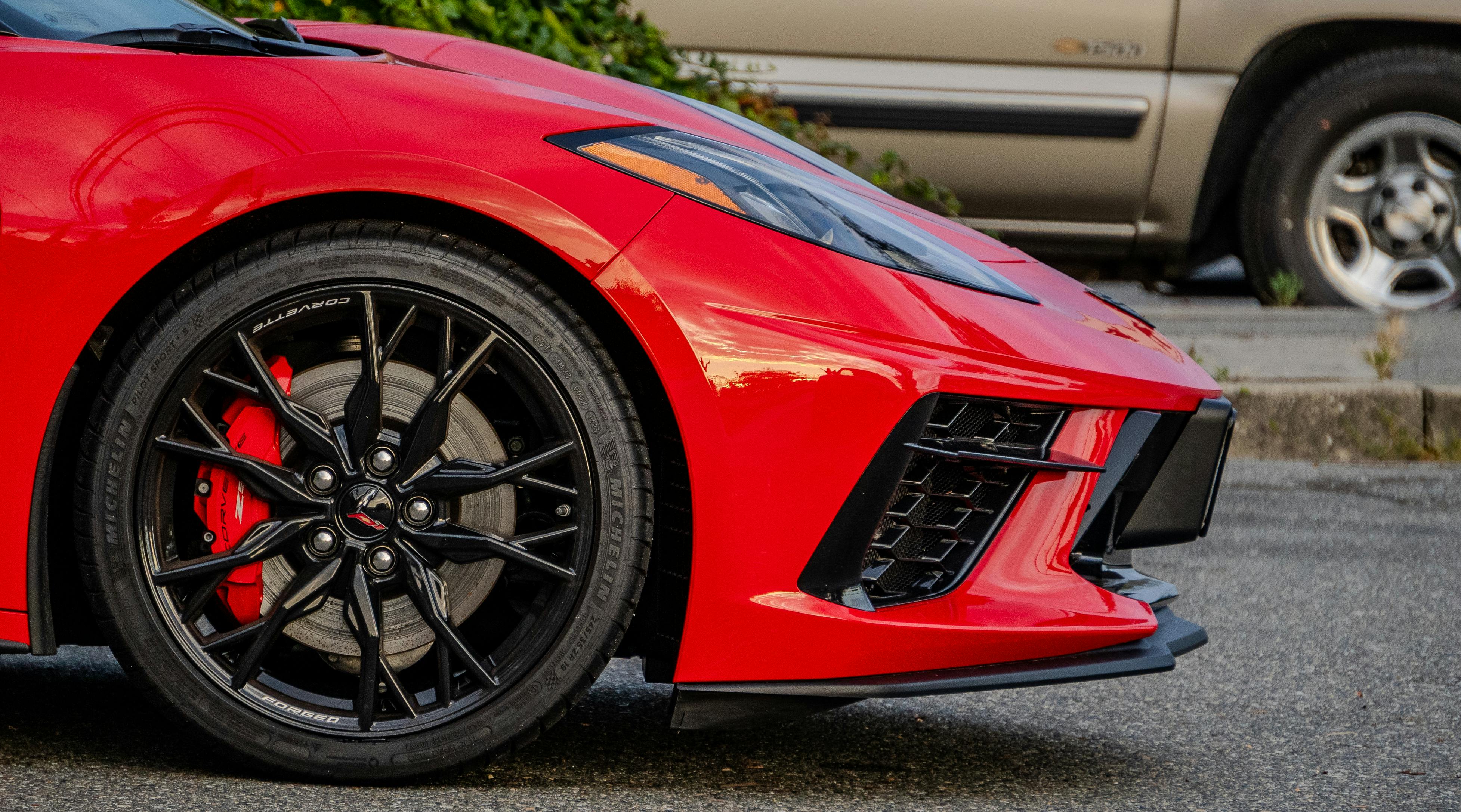 Red Sports Car with Black Alloy Wheel Close-Up · Free Stock Photo