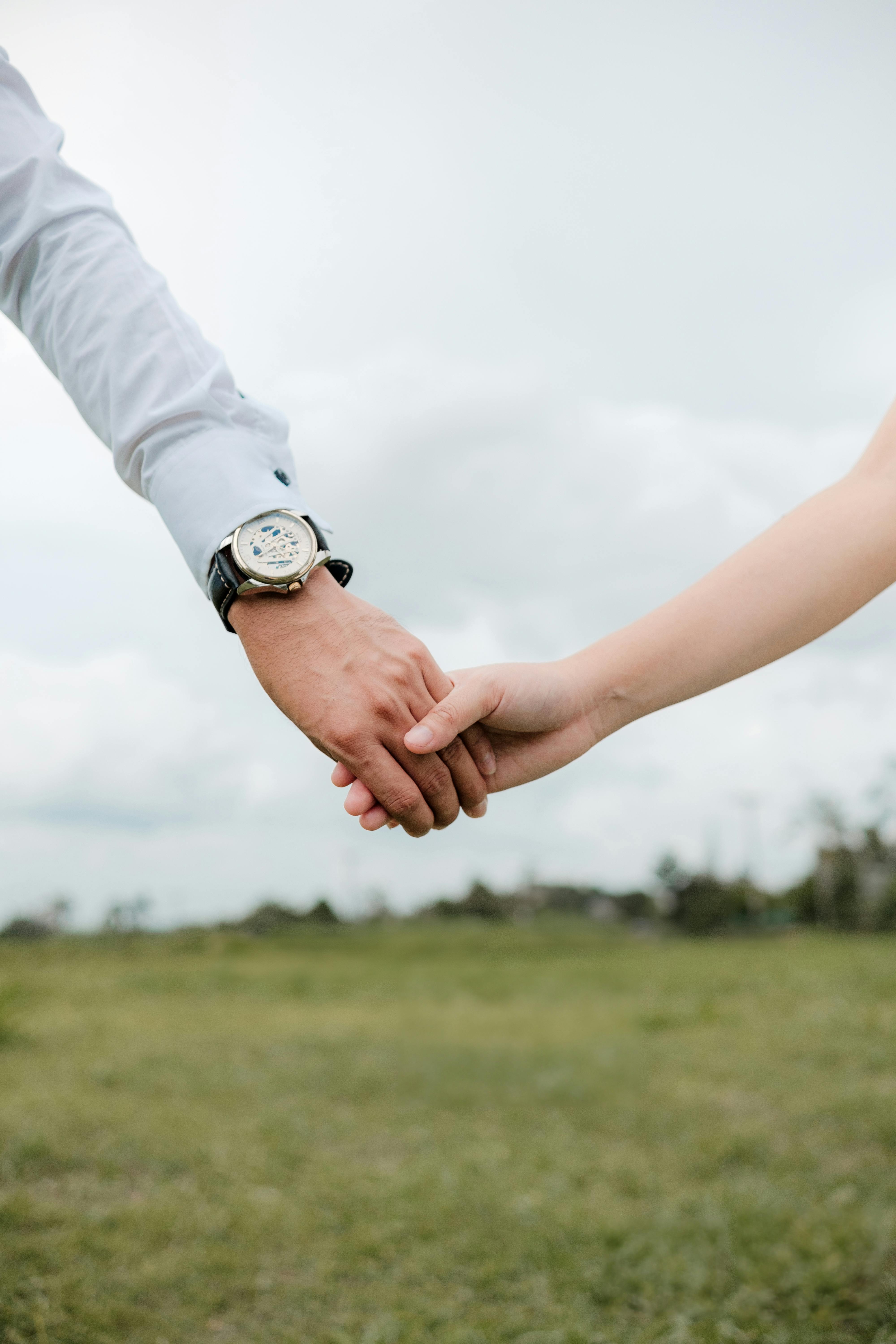Romantic Couple Holding Hands Outdoors · Free Stock Photo