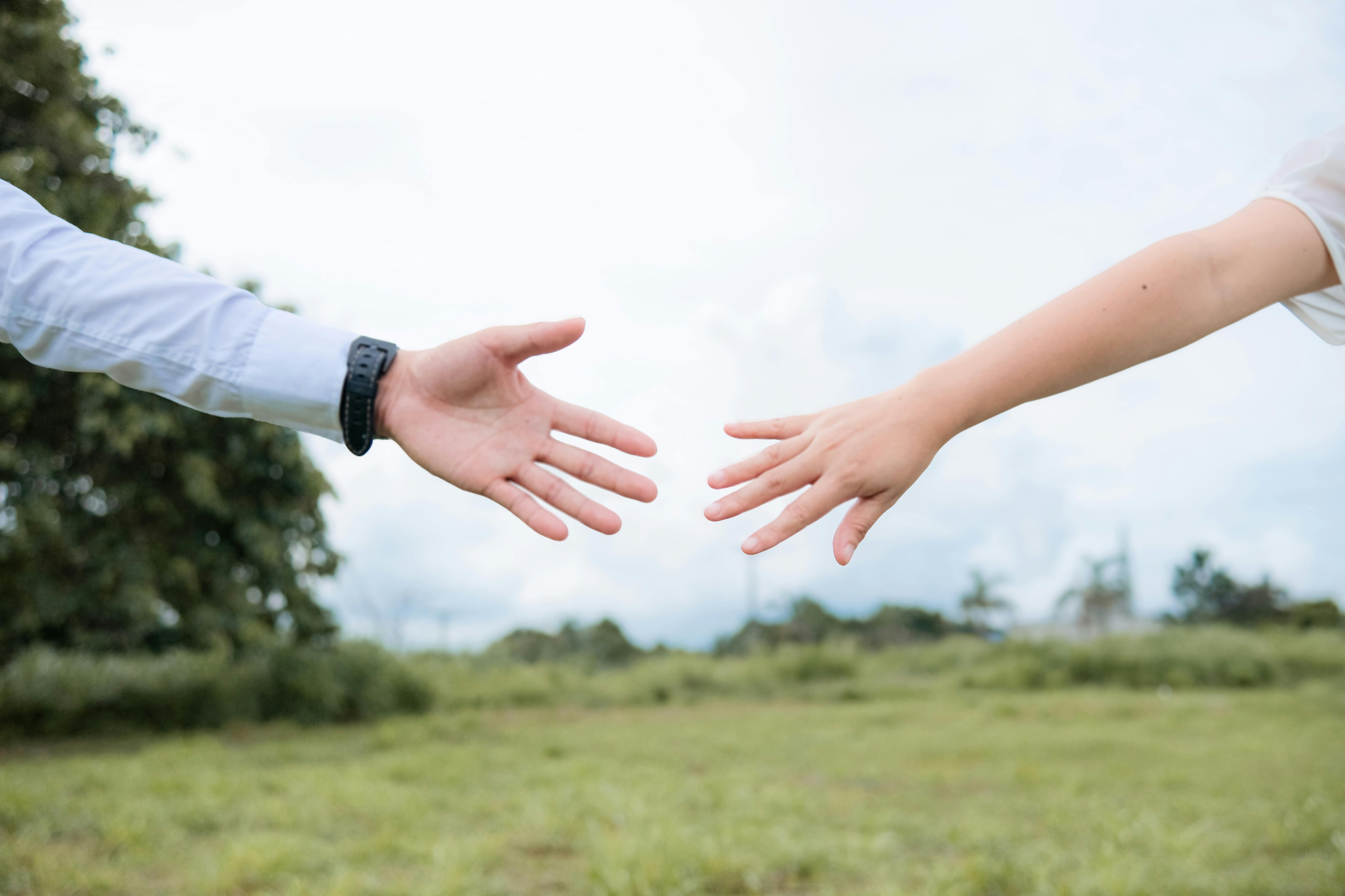 Romantic Couple Reaching Hands Outdoors · Free Stock Photo