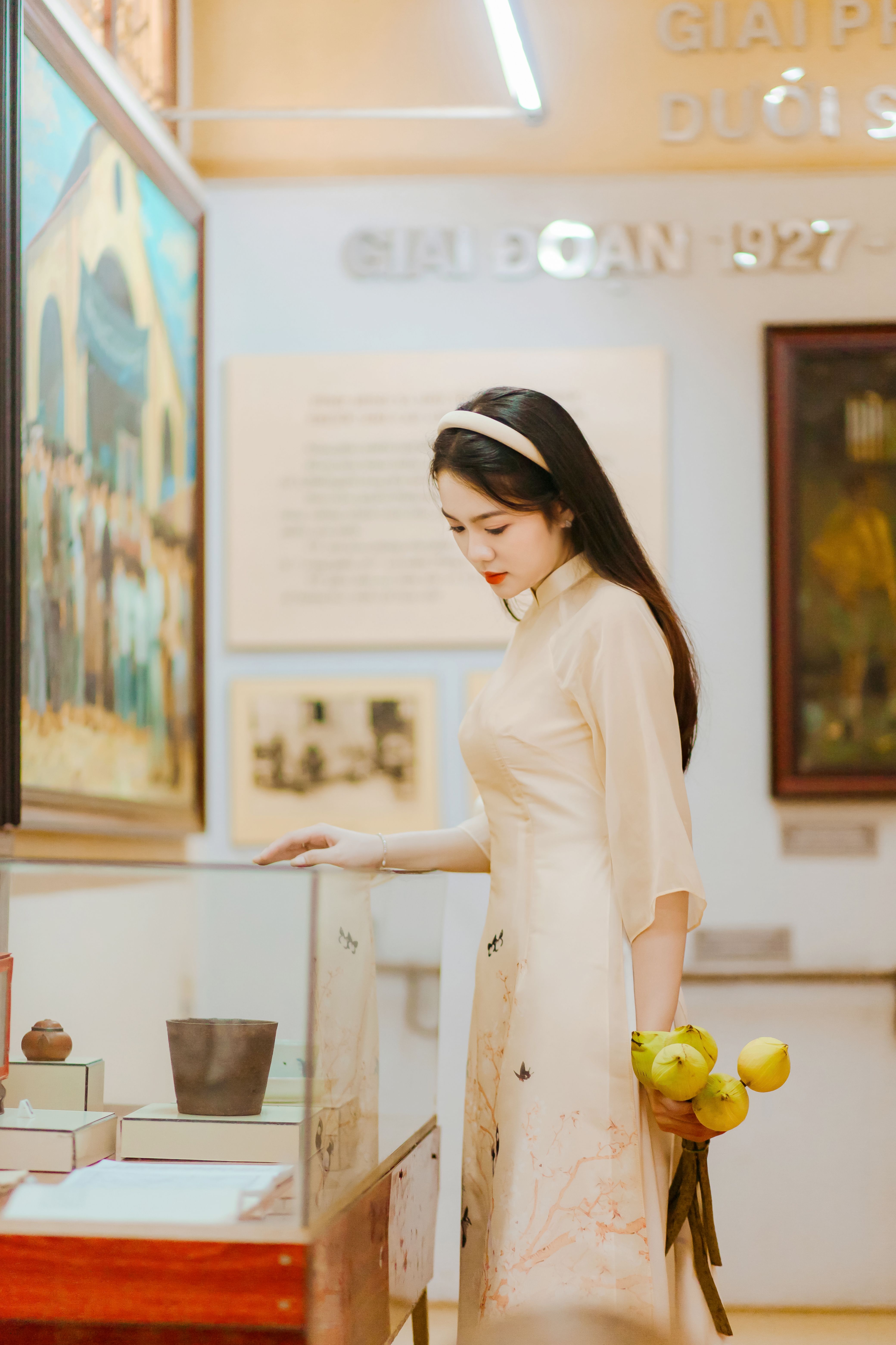 Woman in a Museum with Artifacts and Flowers · Free Stock Photo