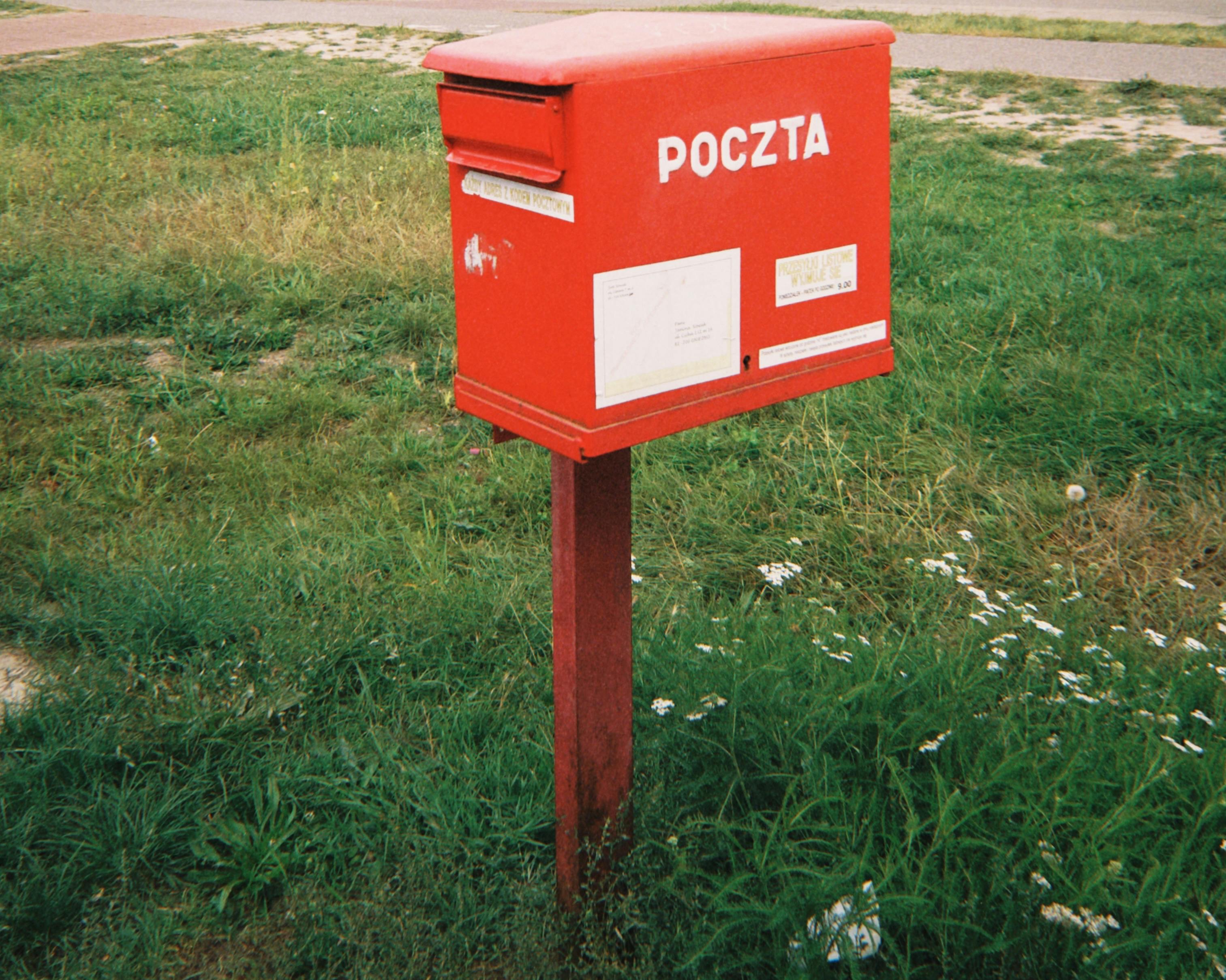 Red Mailbox Standing on Green Grass Outdoors · Free Stock Photo