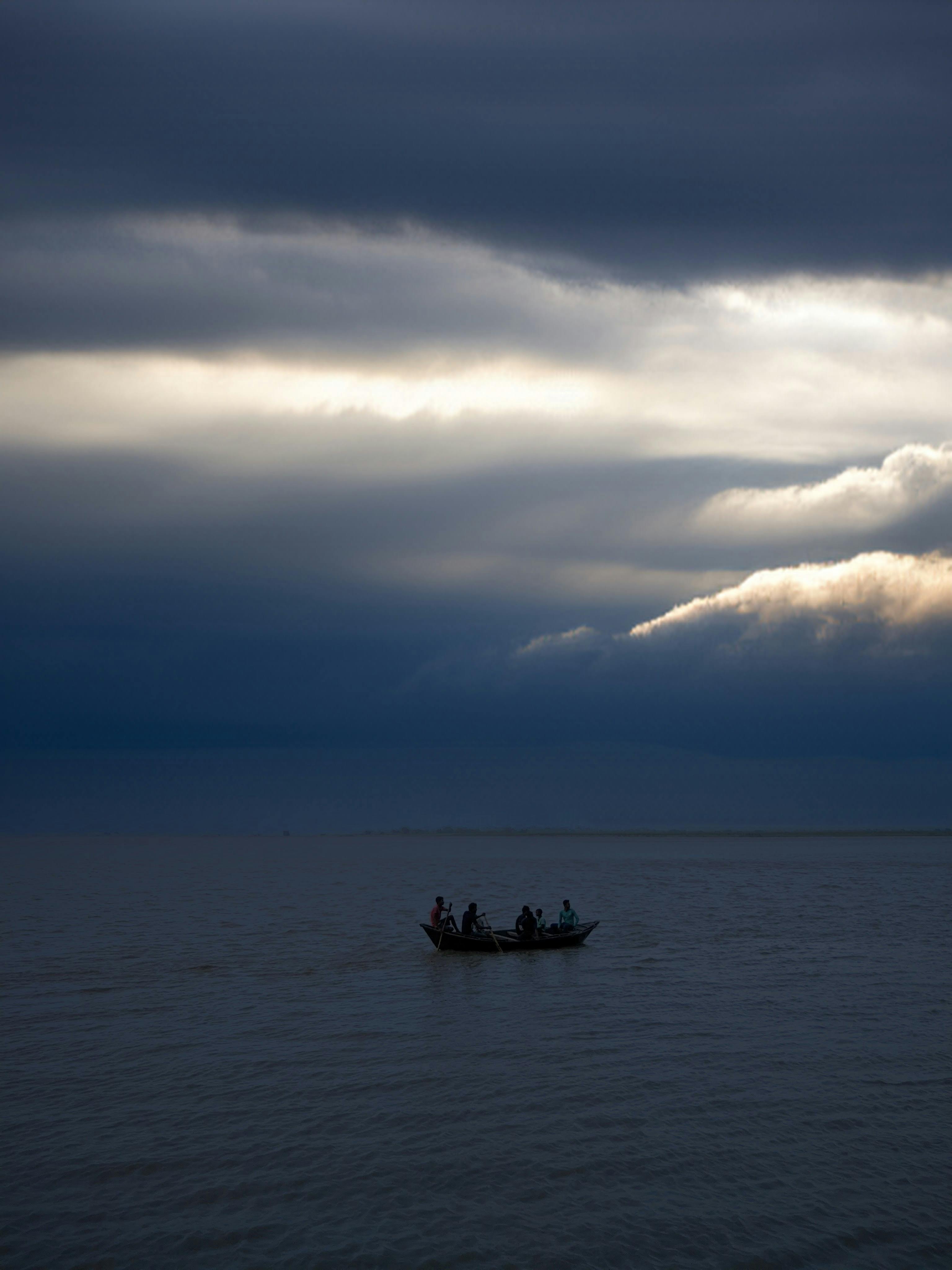 Dramatic Seascape with Boat Under Stormy Sky · Free Stock Photo