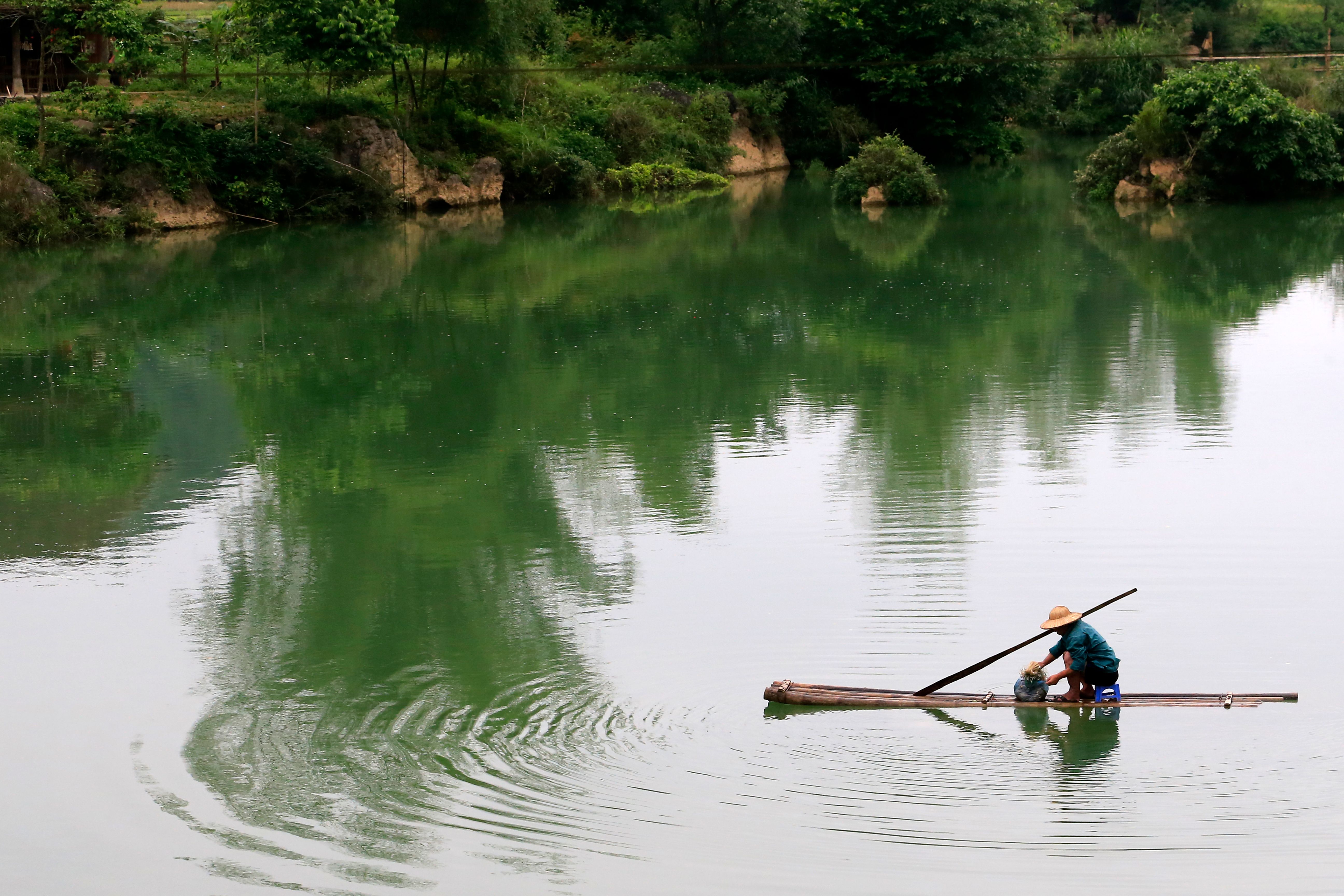 Peaceful River Scene with Traditional Boatman · Free Stock Photo