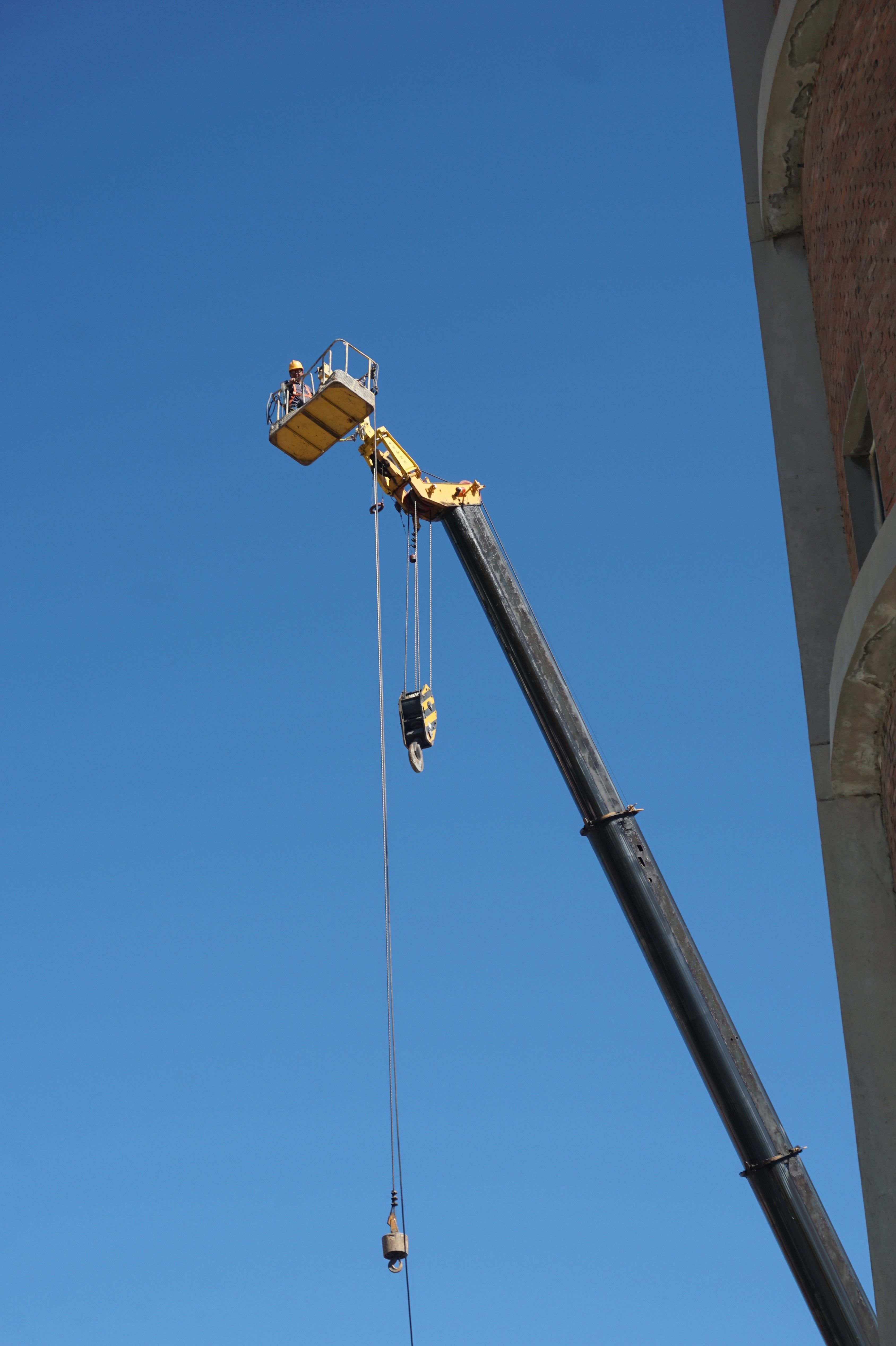 Construction Crane with Operator Under Blue Sky · Free Stock Photo