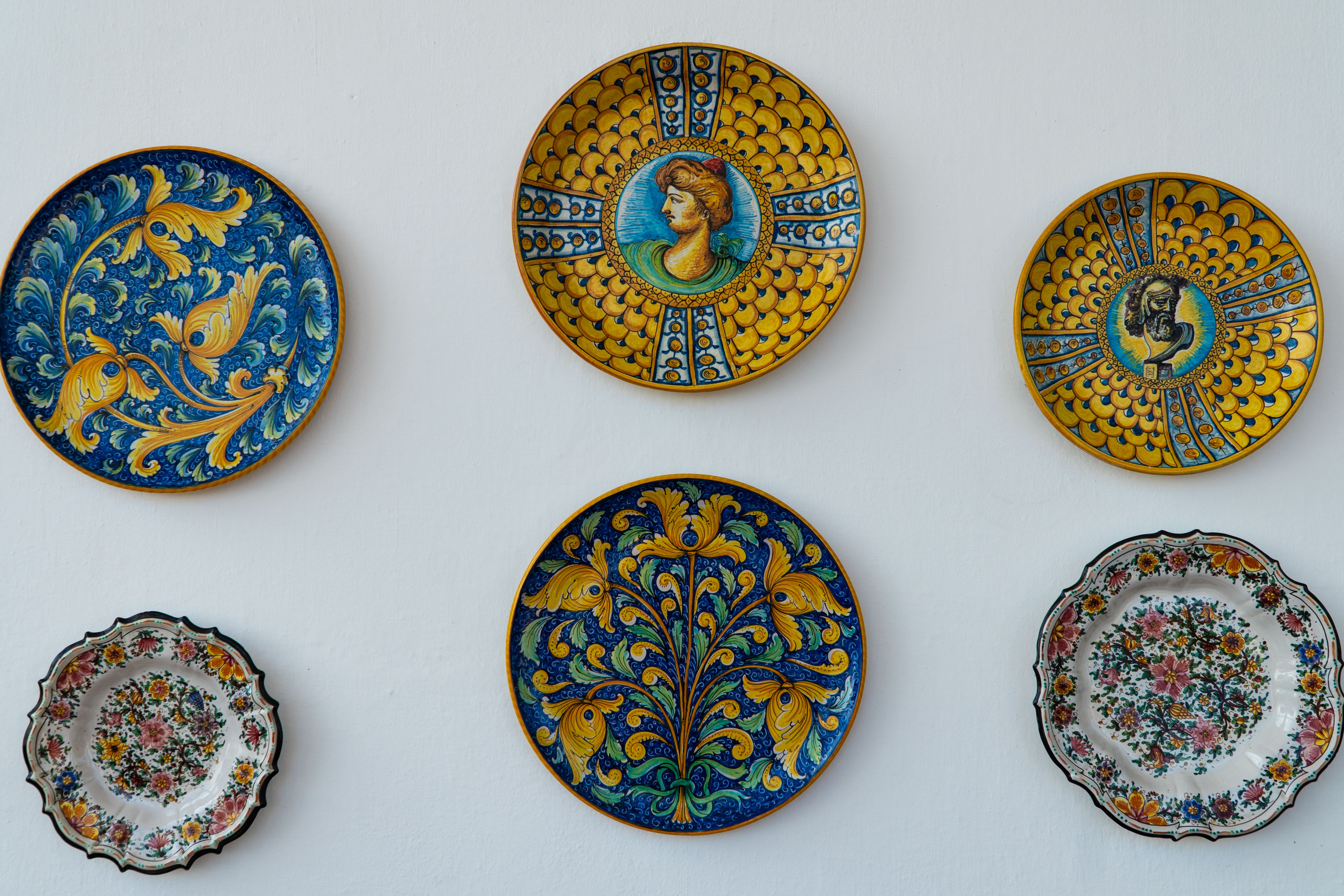 Colorful Italian Ceramic Plates Displayed on a Wall · Free Stock Photo