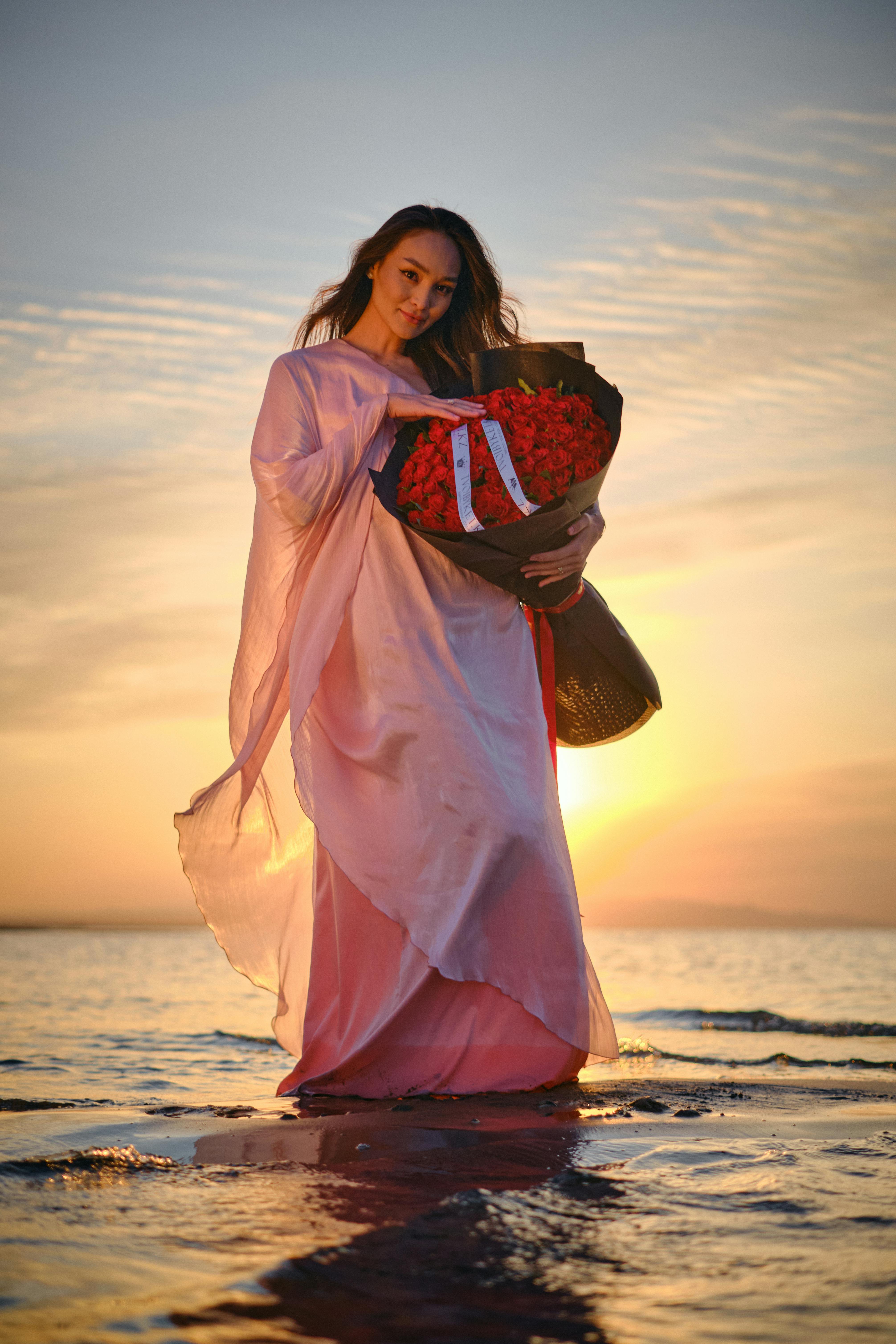 Woman with Roses at Sunset by the Sea · Free Stock Photo