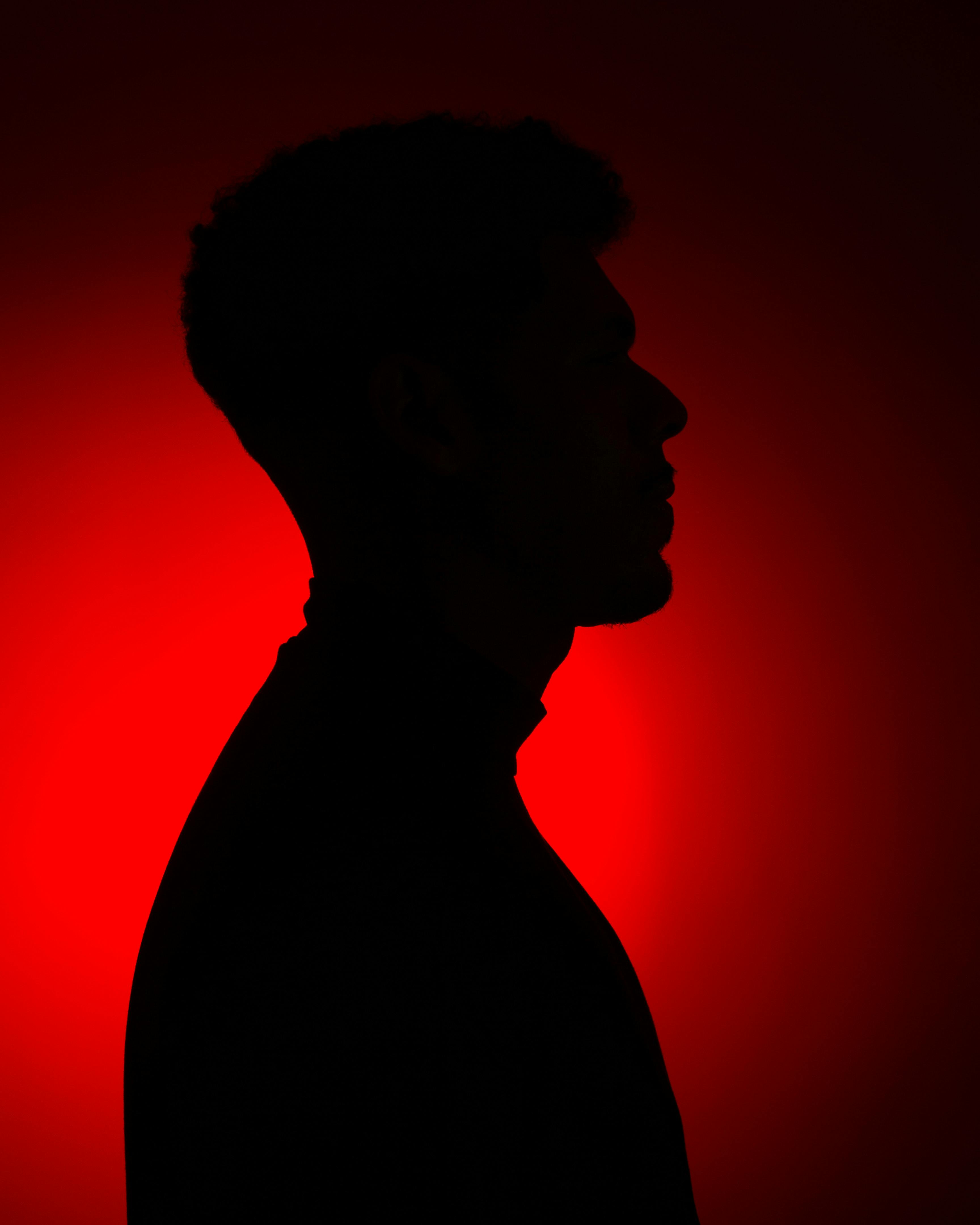 Silhouette of a Man Against Red Background · Free Stock Photo