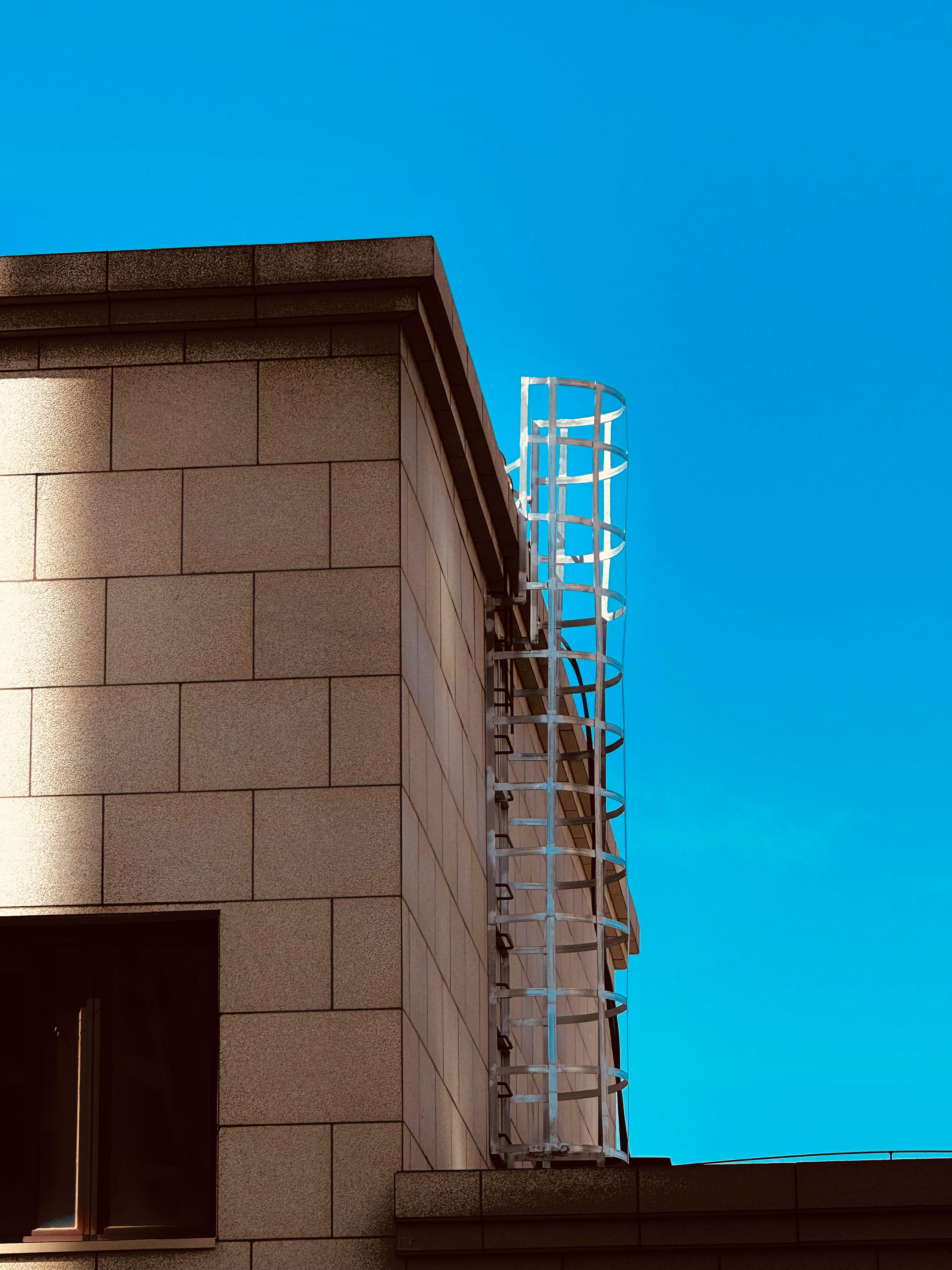 Modern Building Exterior with Ladder Against Blue Sky · Free Stock Photo