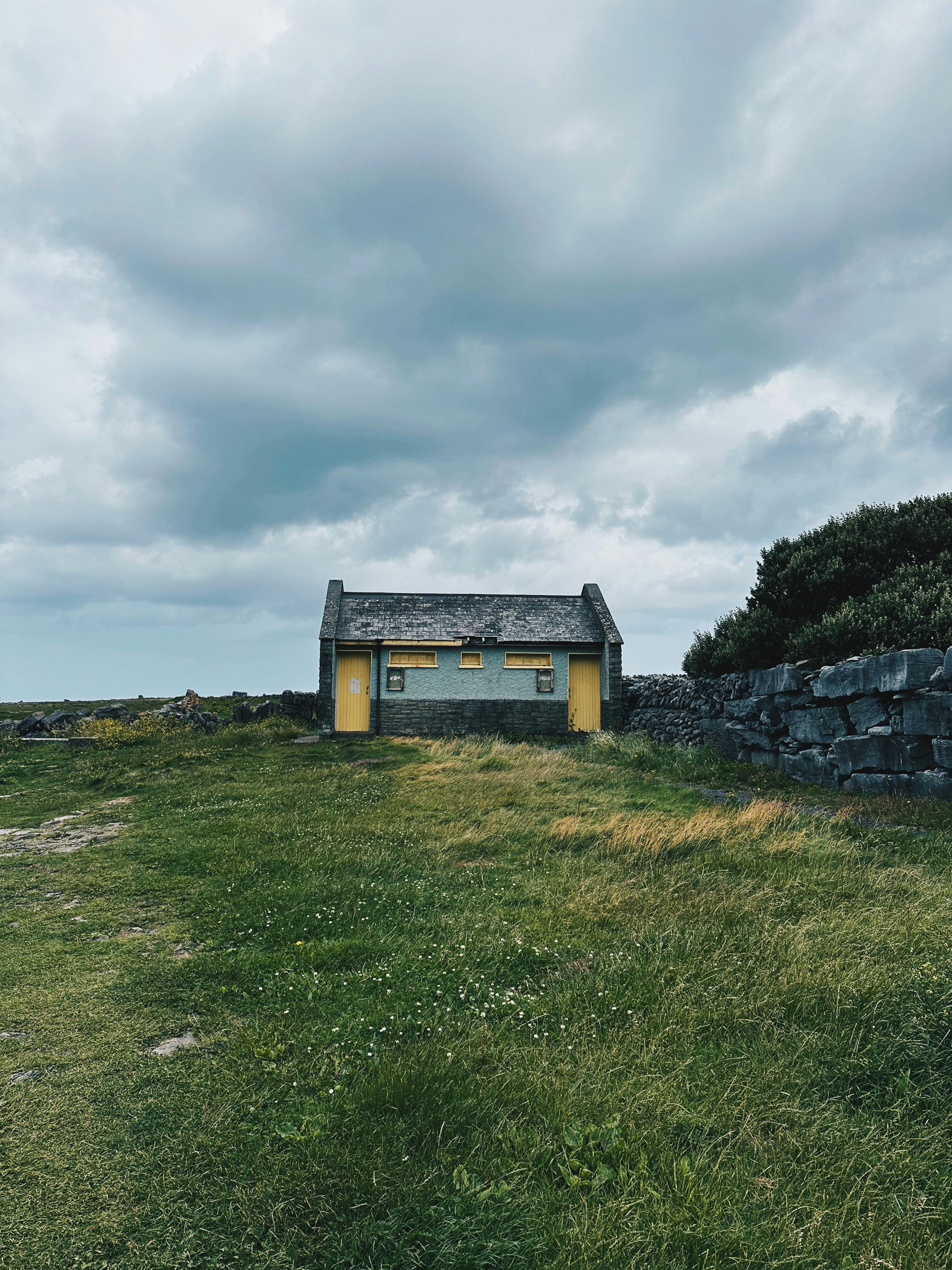 Rustic Stone Building in Open Green Field Under Cloudy Sky · Free Stock ...