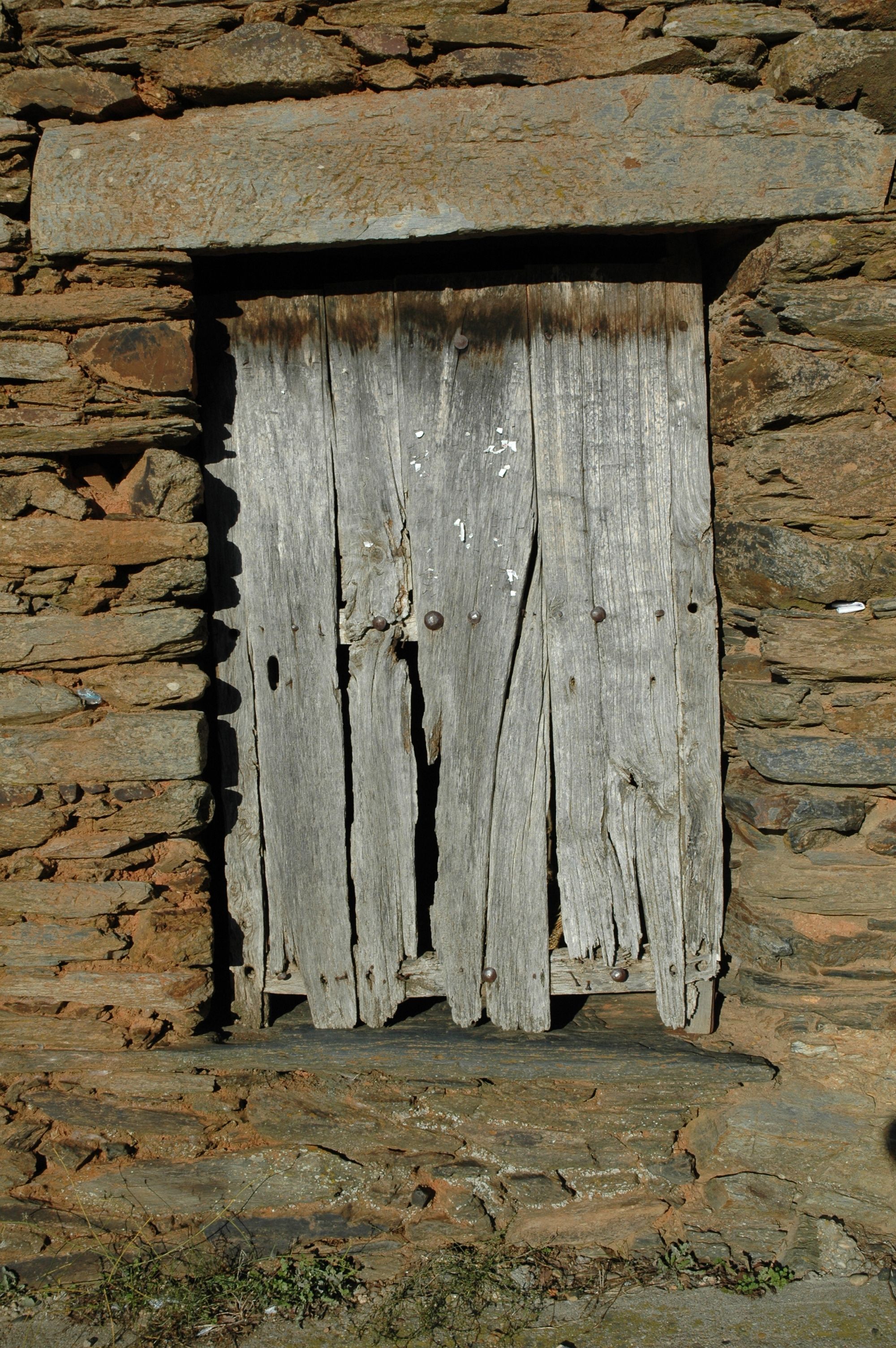 Rustic Wooden Door on Stone Wall Close-Up · Free Stock Photo