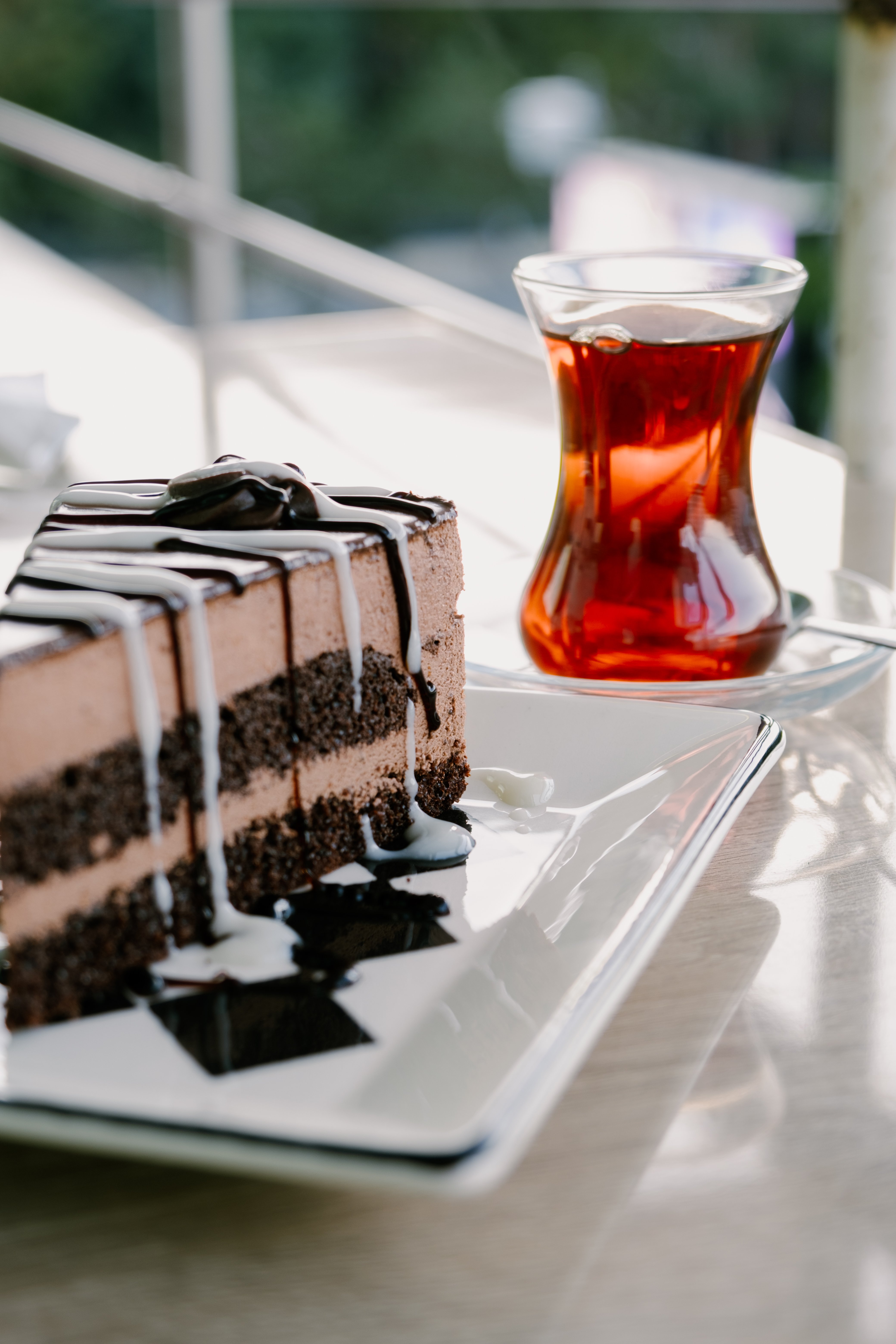 Chocolate Cake with Tea on Sunlit Patio · Free Stock Photo