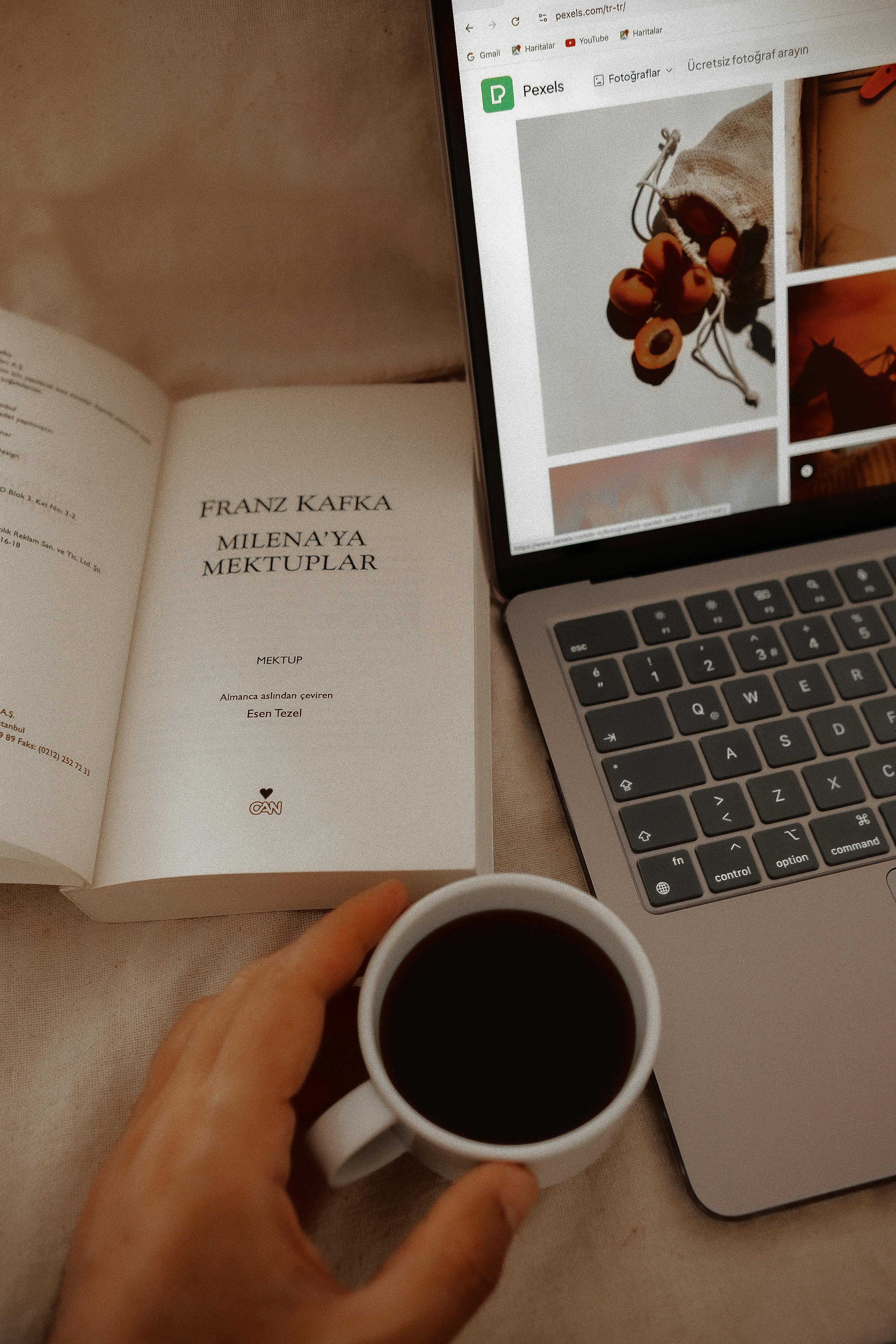 Cozy Reading Setup with Coffee and Laptop · Free Stock Photo