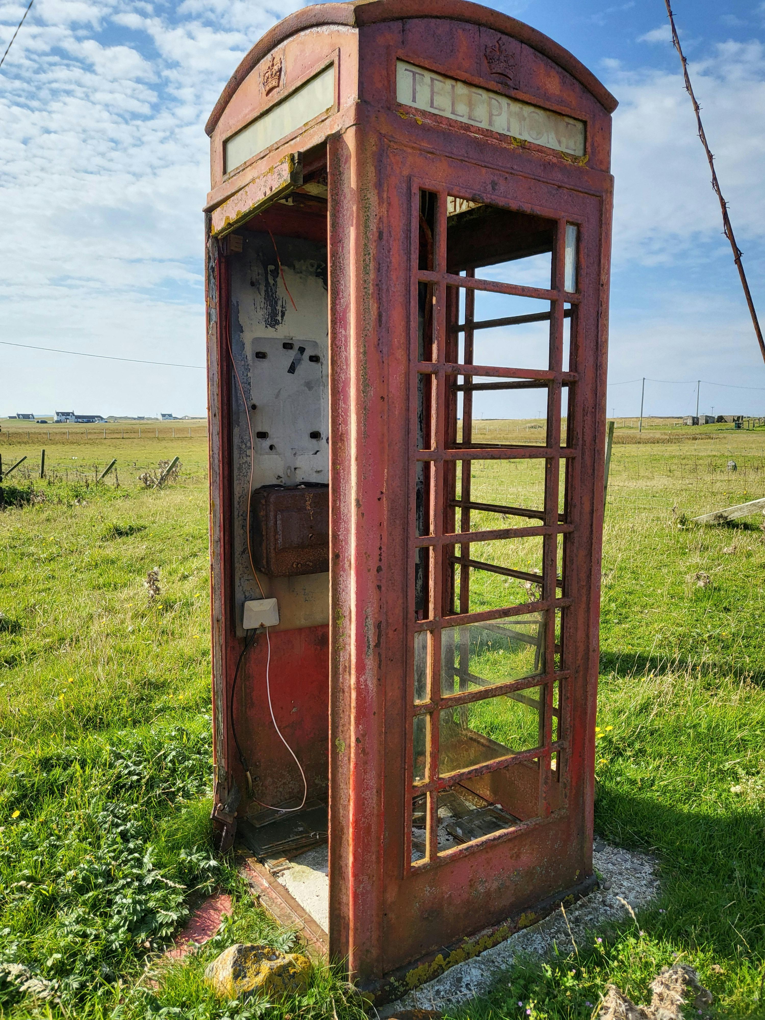 Rusty Red Telephone Box in Rural Field · Free Stock Photo