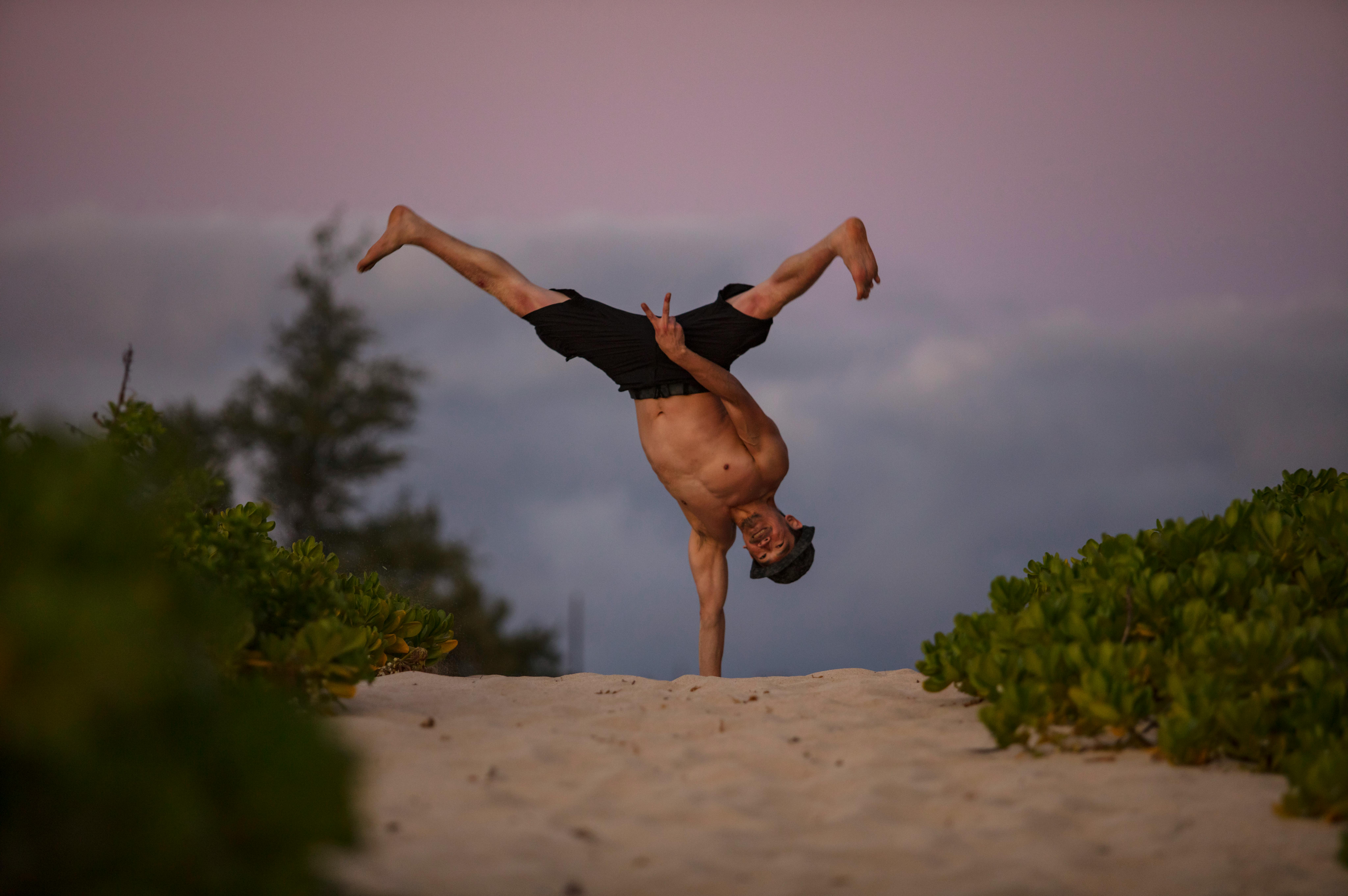 Man Performing One-Handed Handstand on Beach · Free Stock Photo