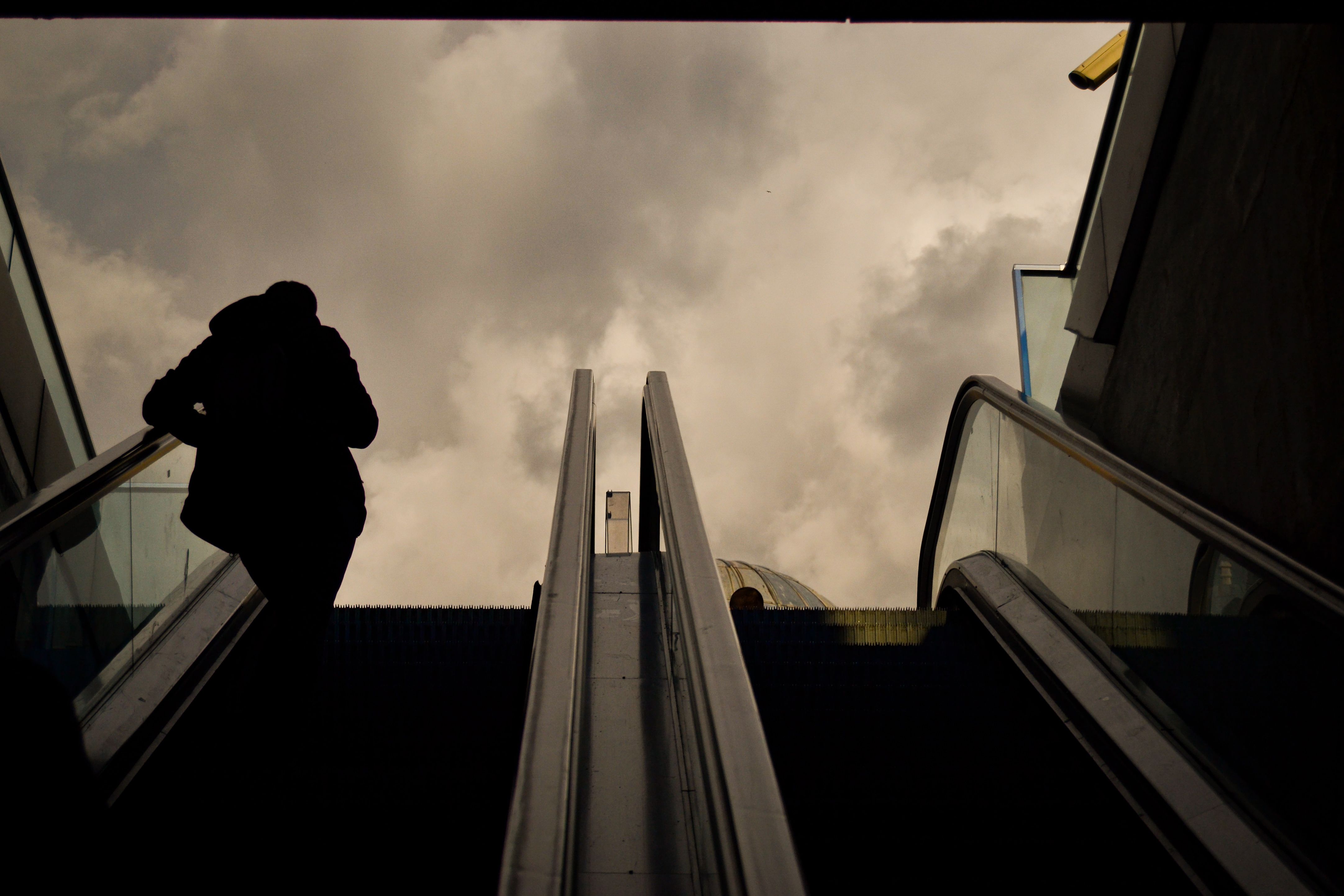 Silhouette on Escalator Under Dramatic Sky · Free Stock Photo