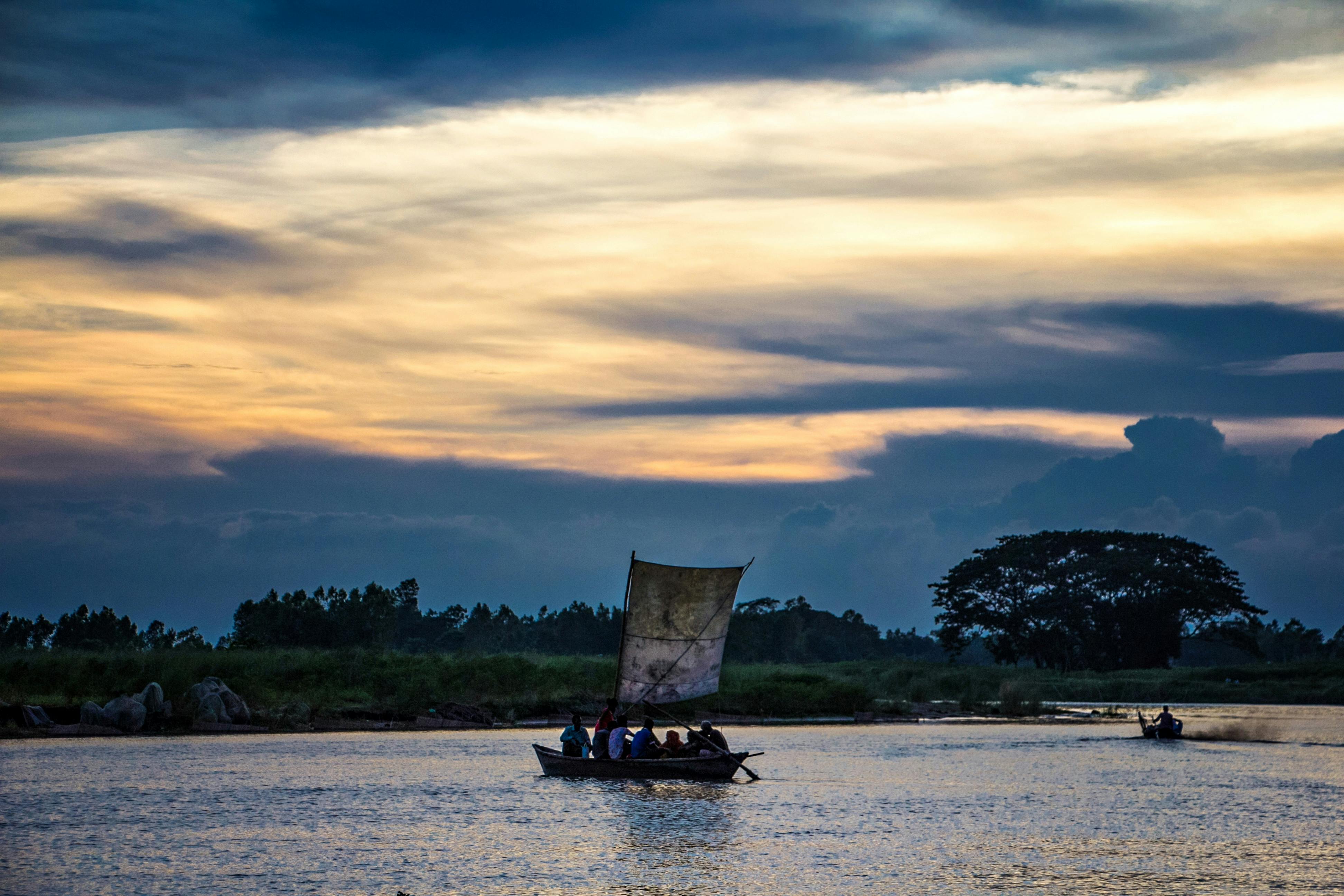 Serene Sunset Boat Ride on Tranquil Lake · Free Stock Photo