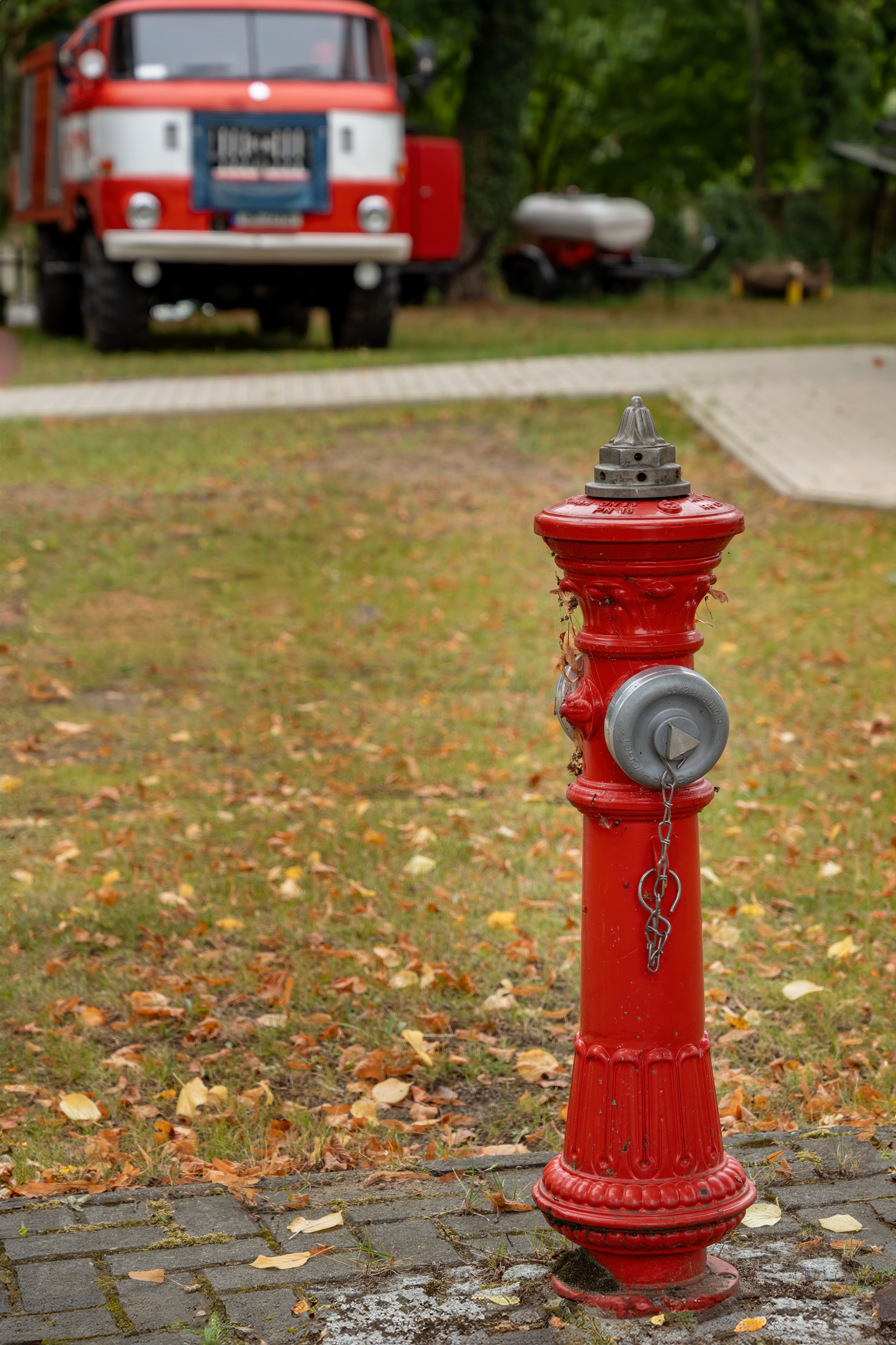 Red Fire Hydrant with Firetruck in Background · Free Stock Photo