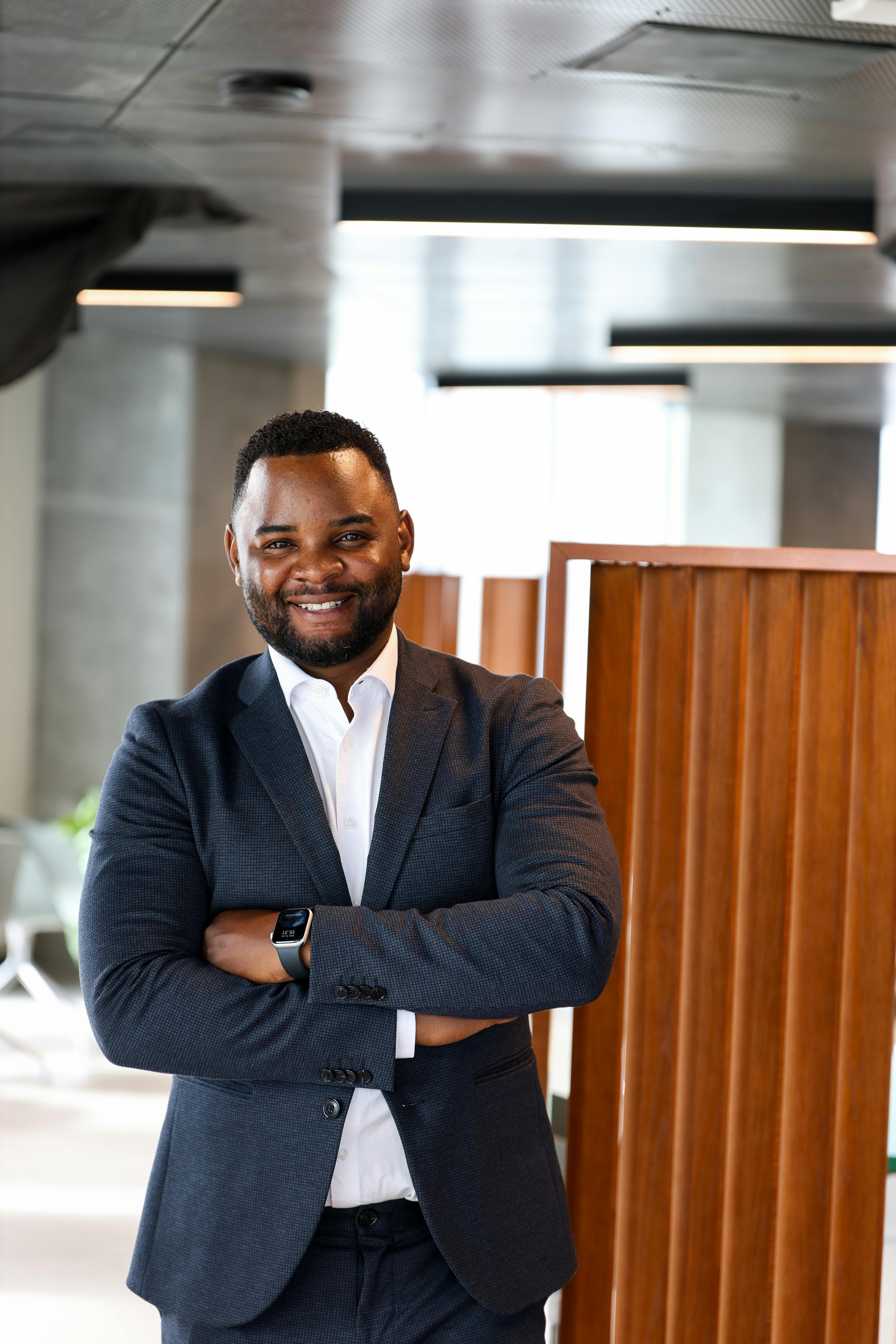 Professional Man Smiling in Modern Office Environment · Free Stock Photo