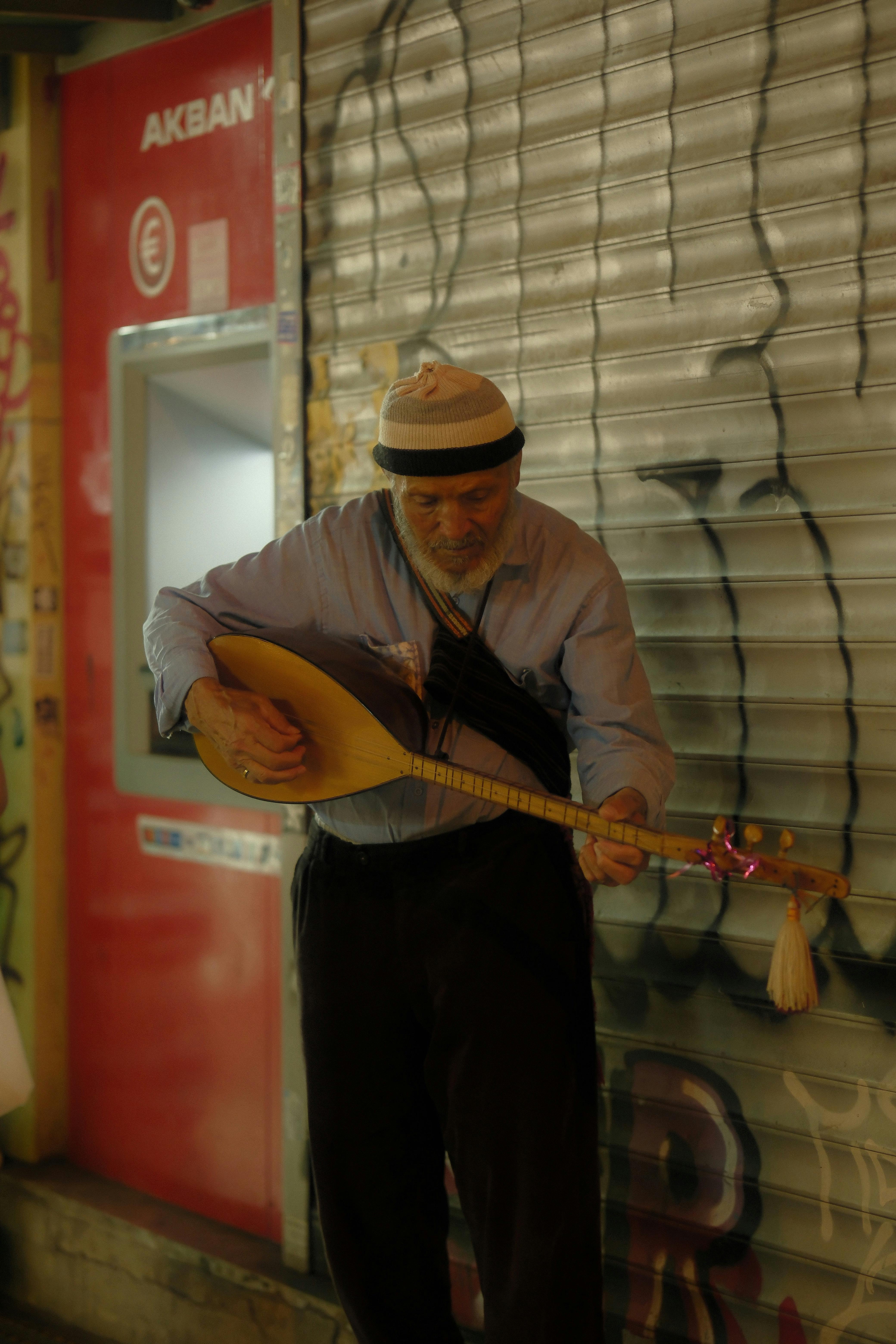 Street Musician Playing Traditional Instrument at Night · Free Stock Photo