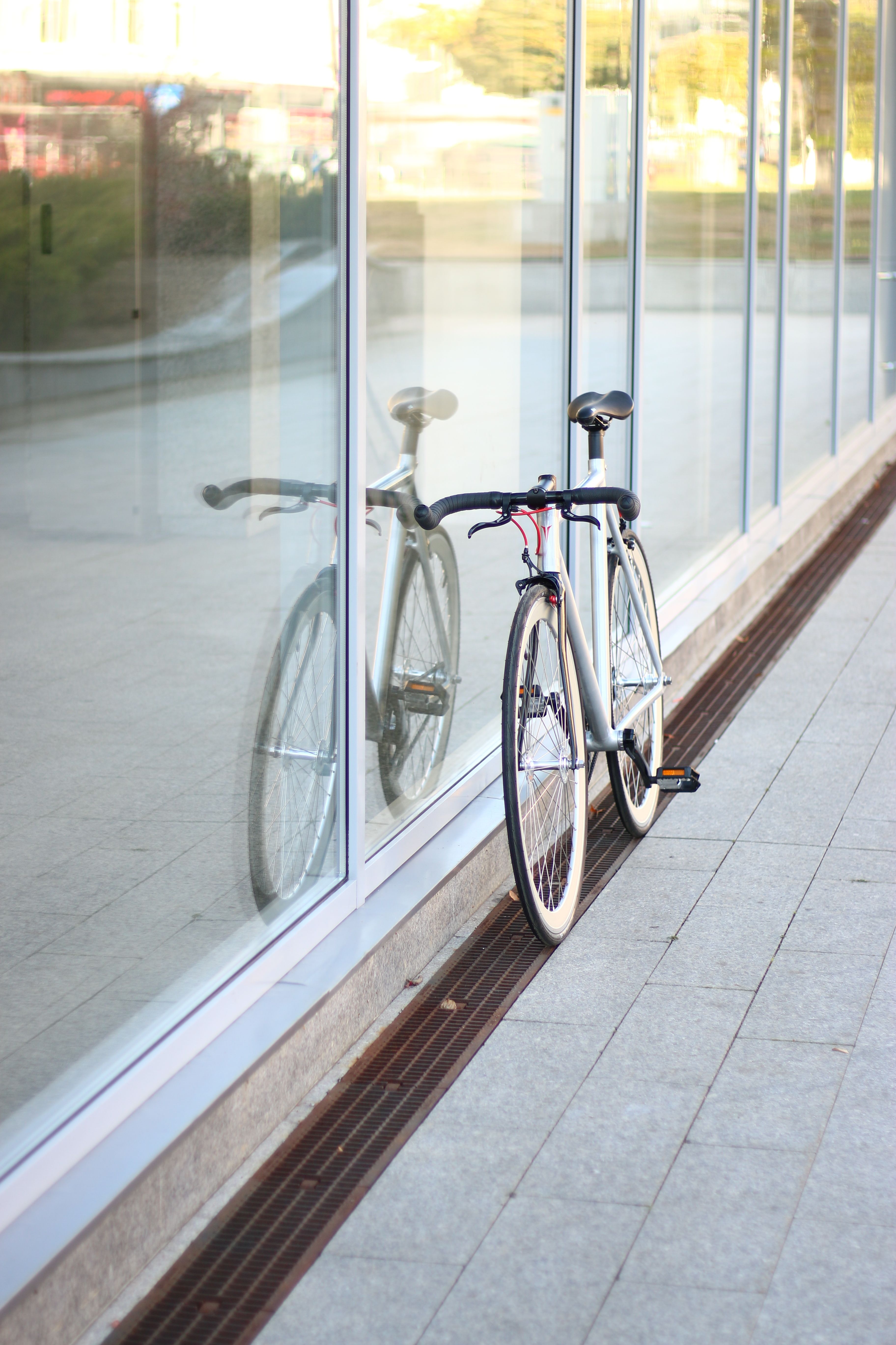 Bicycle Reflected in Glass Building Exterior · Free Stock Photo