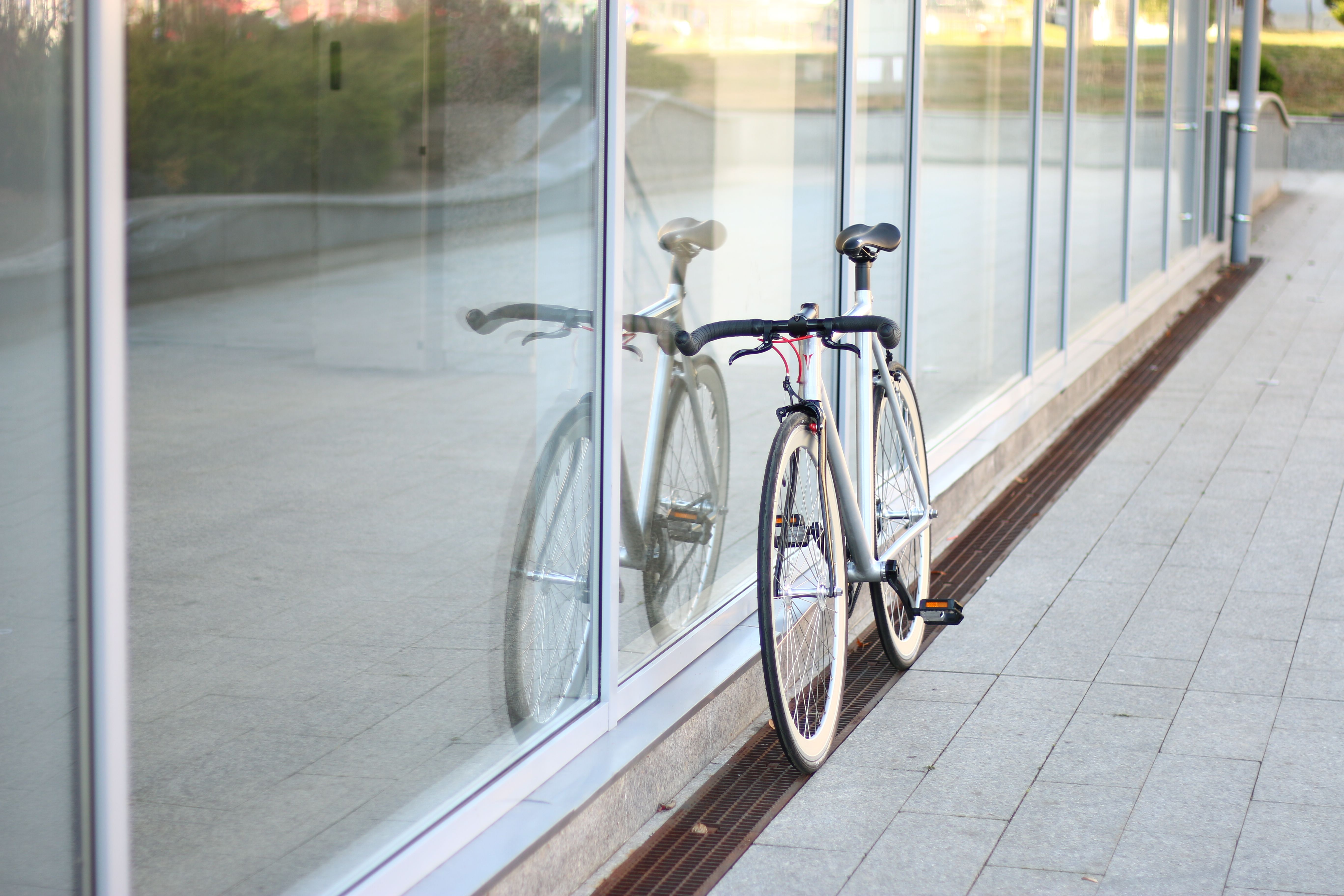 Minimalist Urban Bicycle Reflected in Glass · Free Stock Photo