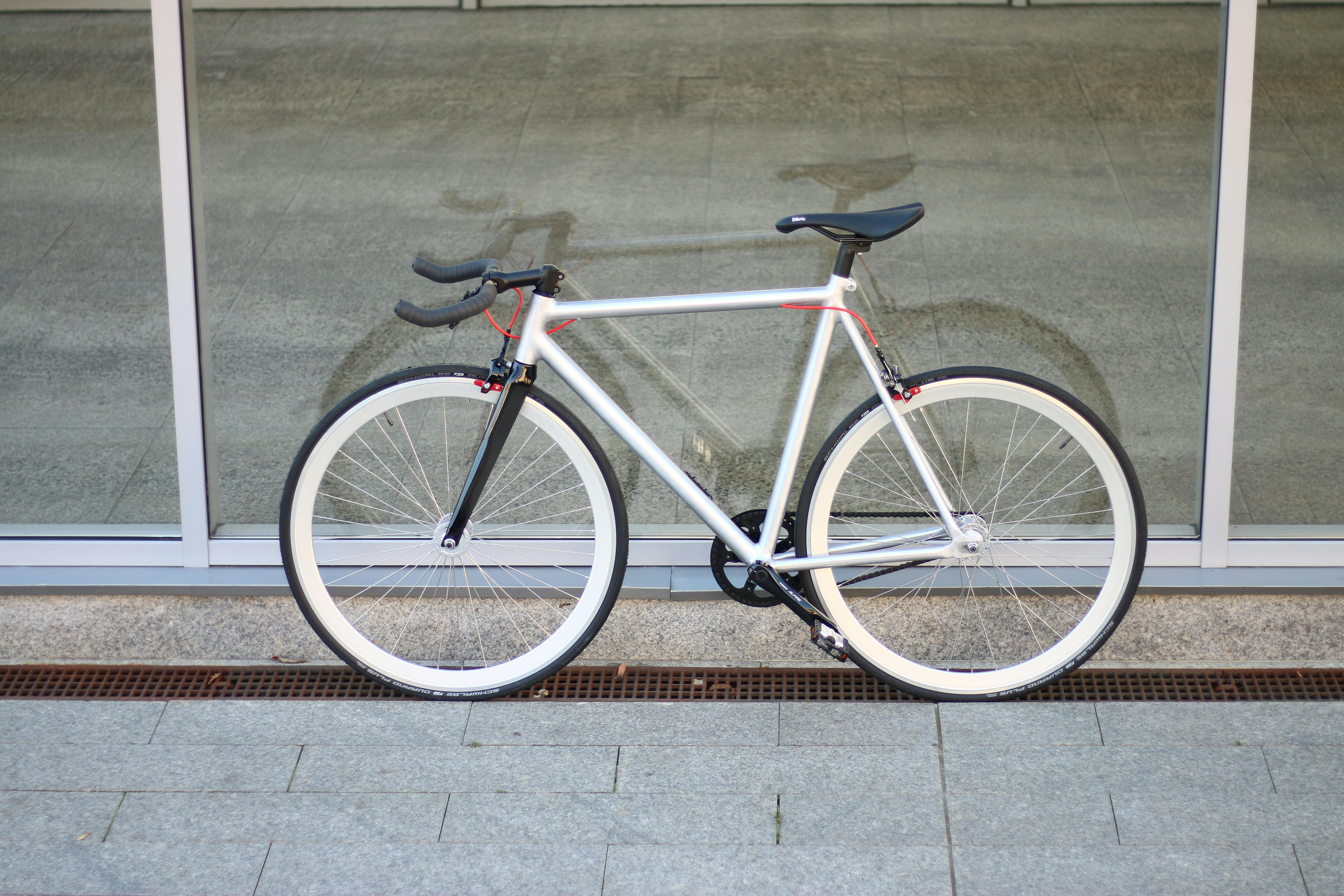 Modern Fixed Gear Bicycle Against Glass Wall · Free Stock Photo