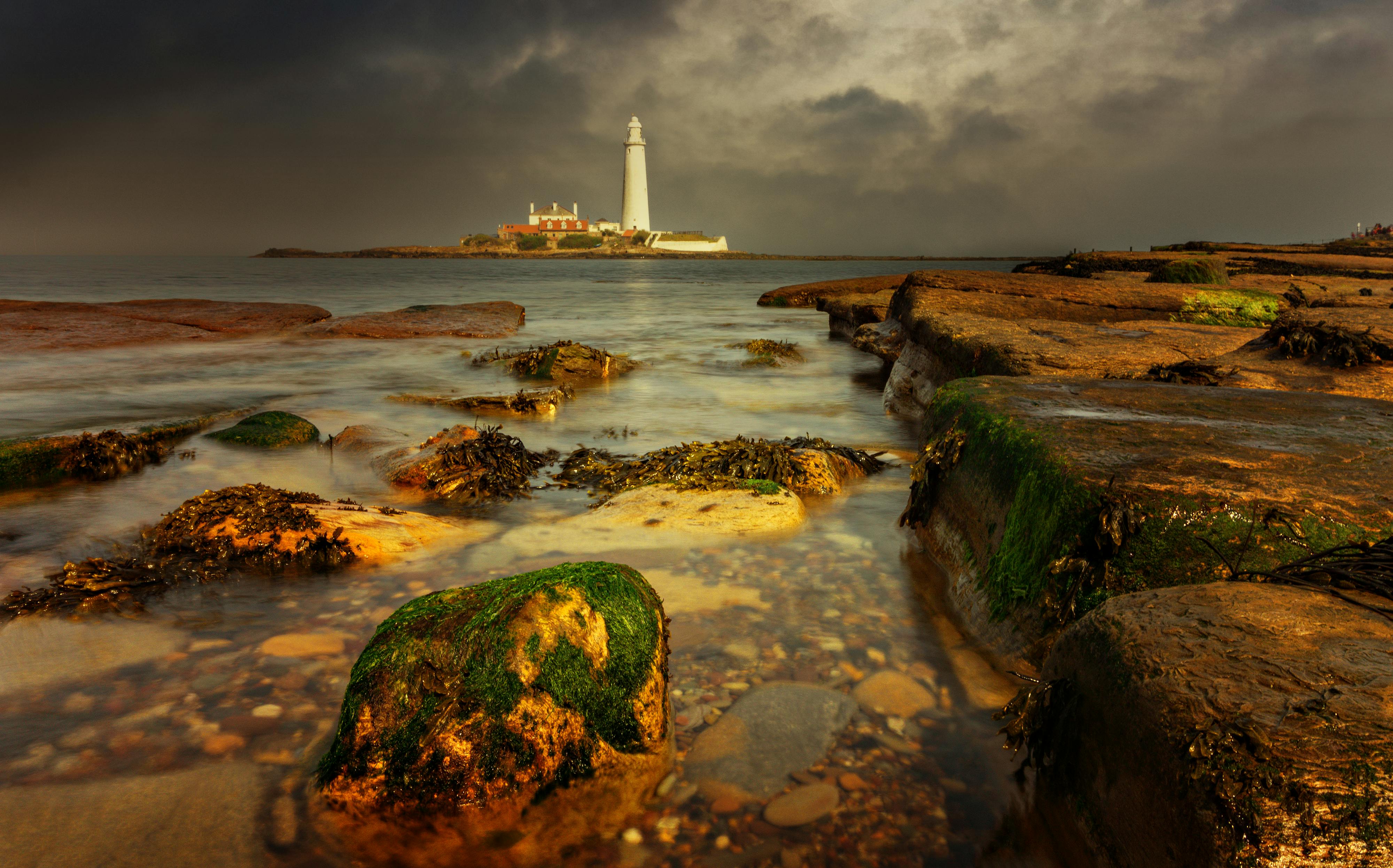 Dramatic Lighthouse View at Rocky Shoreline · Free Stock Photo