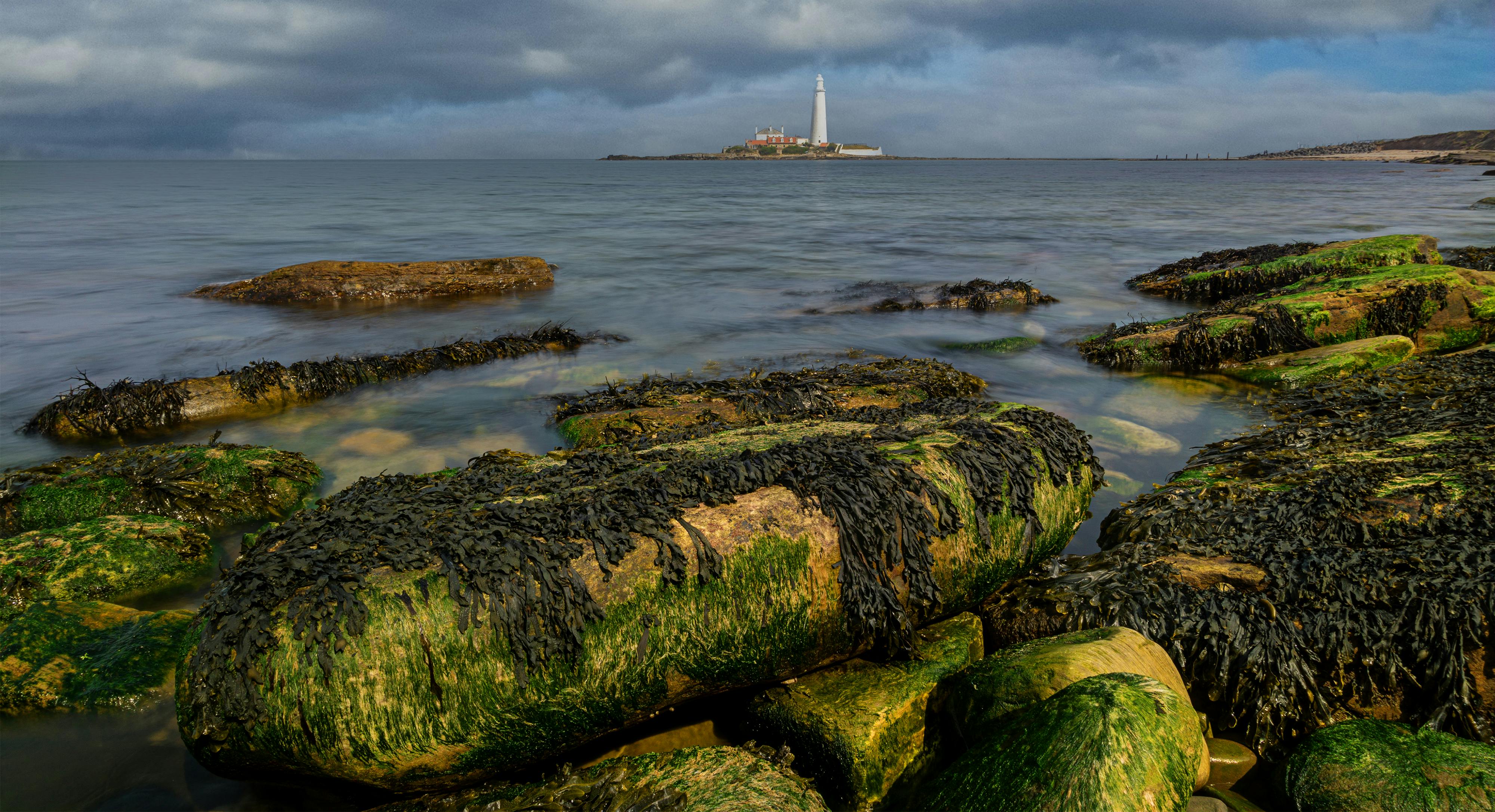 Coastal View of Lighthouse on Rocky Shoreline · Free Stock Photo