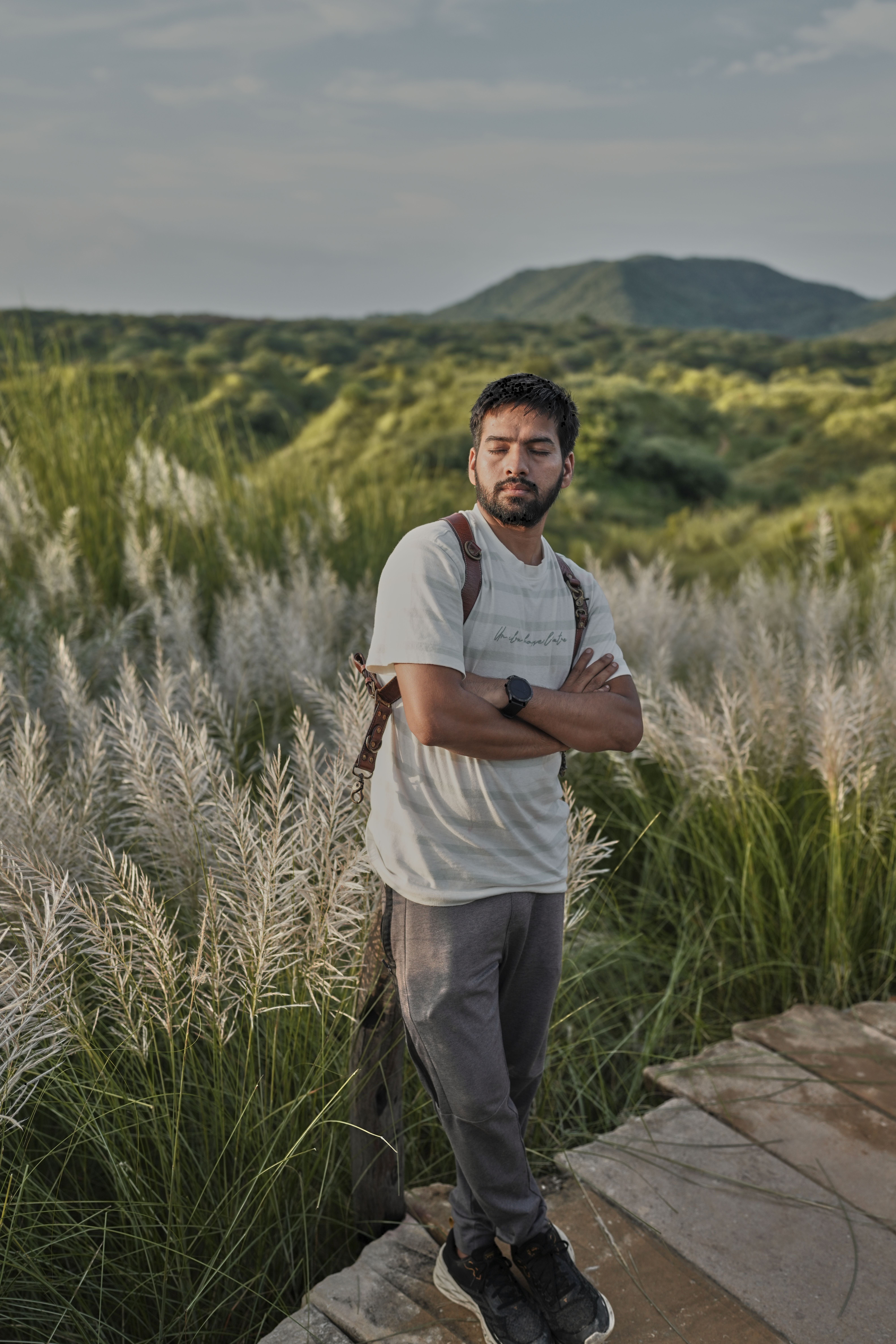 Young Man Posing Outdoors in Scenic Landscape · Free Stock Photo