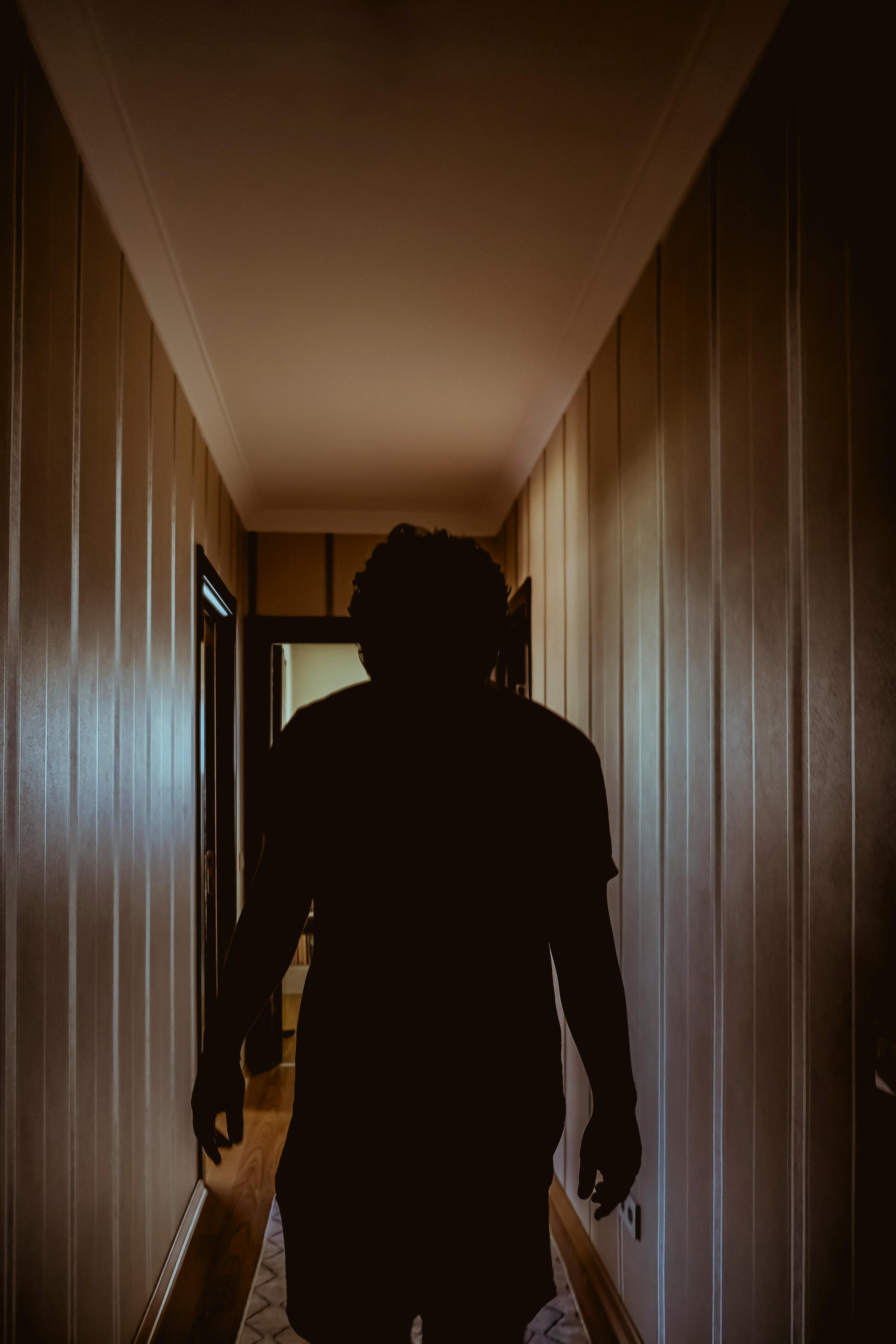 Person Standing in a Hallway in a Dark Room · Free Stock Photo